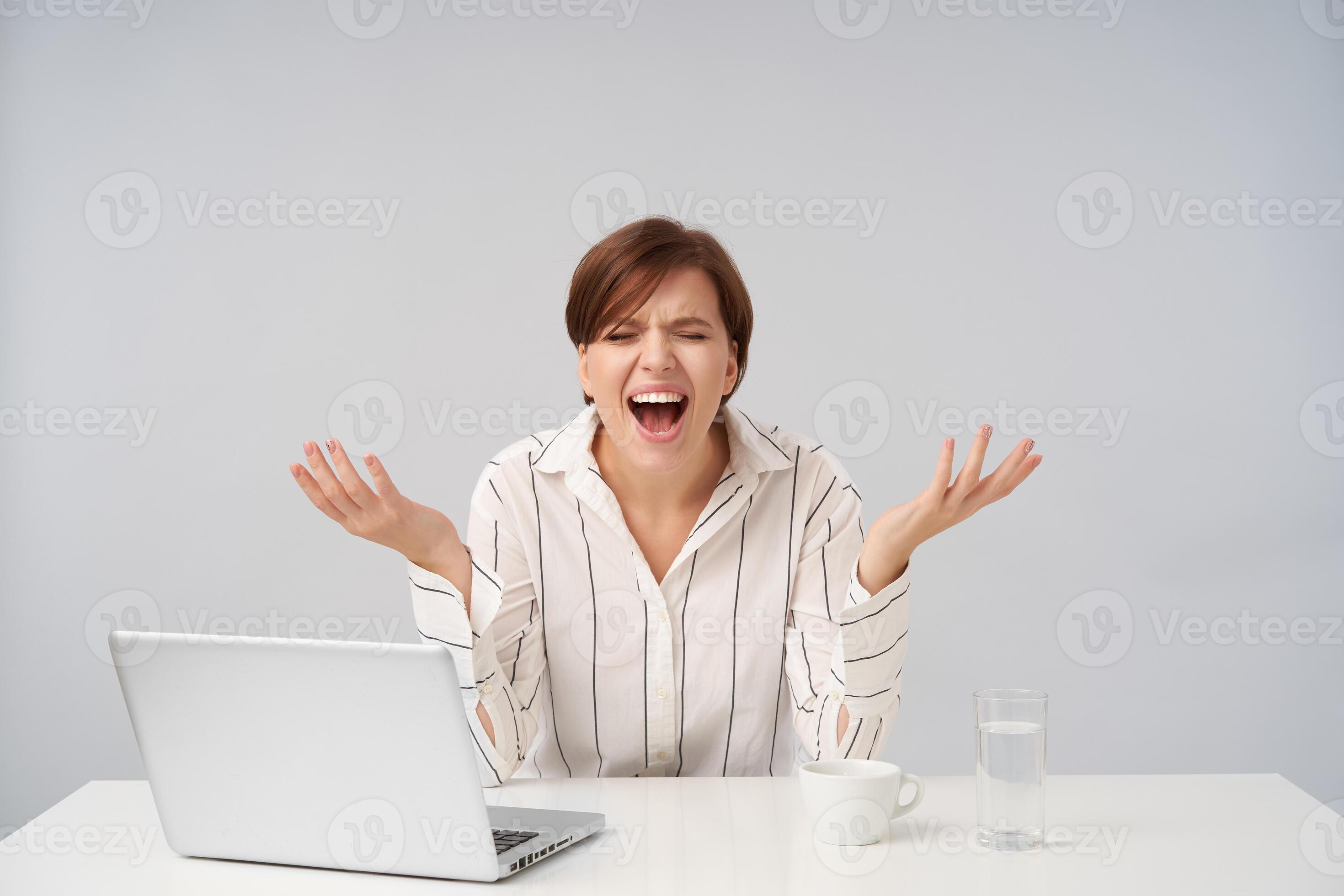 Stressed young short haired brunette woman with natural makeup keeping ...