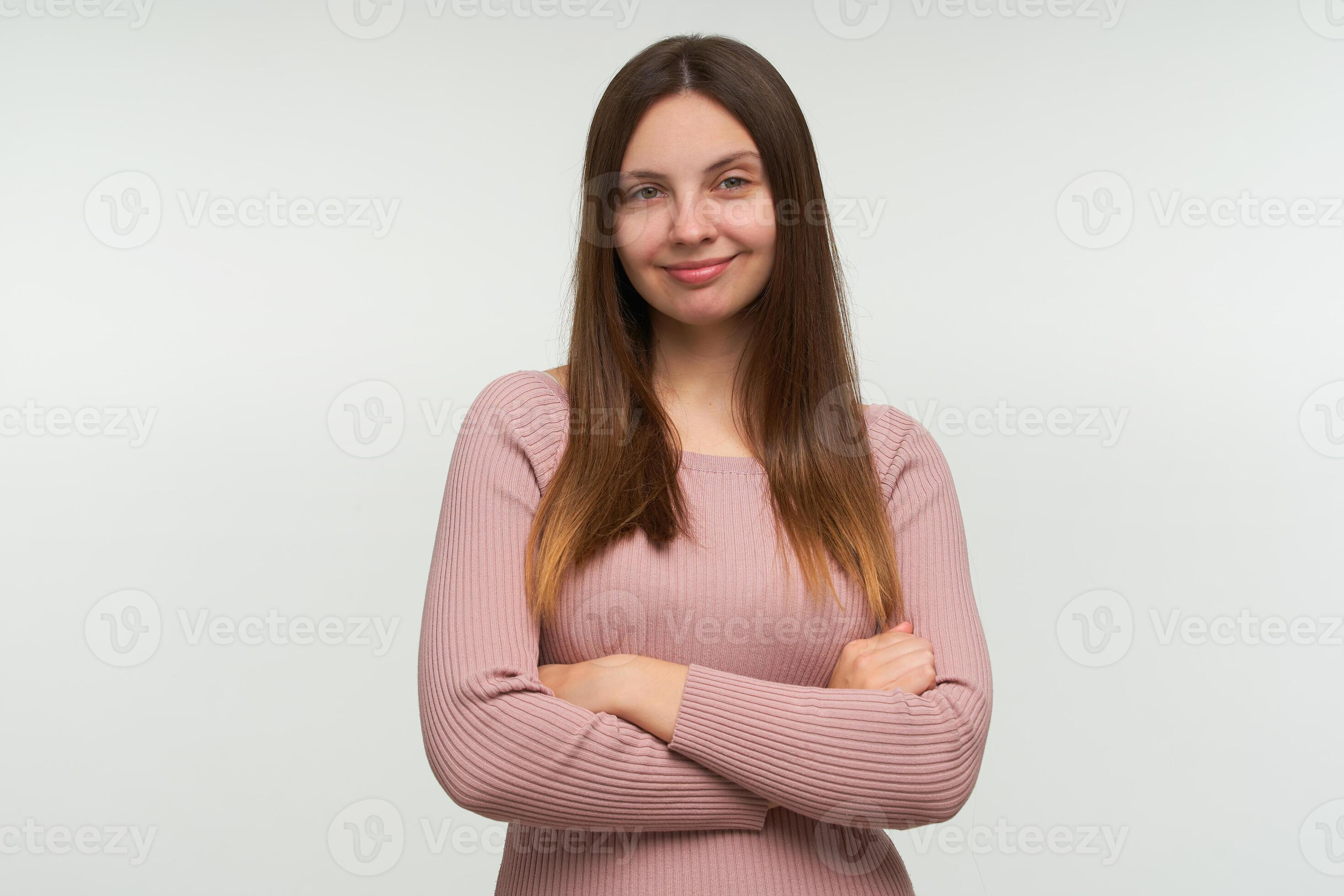 Young woman stands thoughtful, with a sly smile, considering a cunning ...