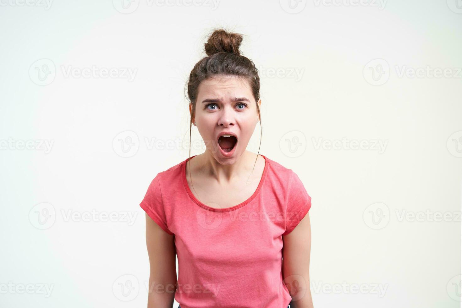 Indoor Shot Of Stressed Young Brown Haired Woman With Bun Hairstyle