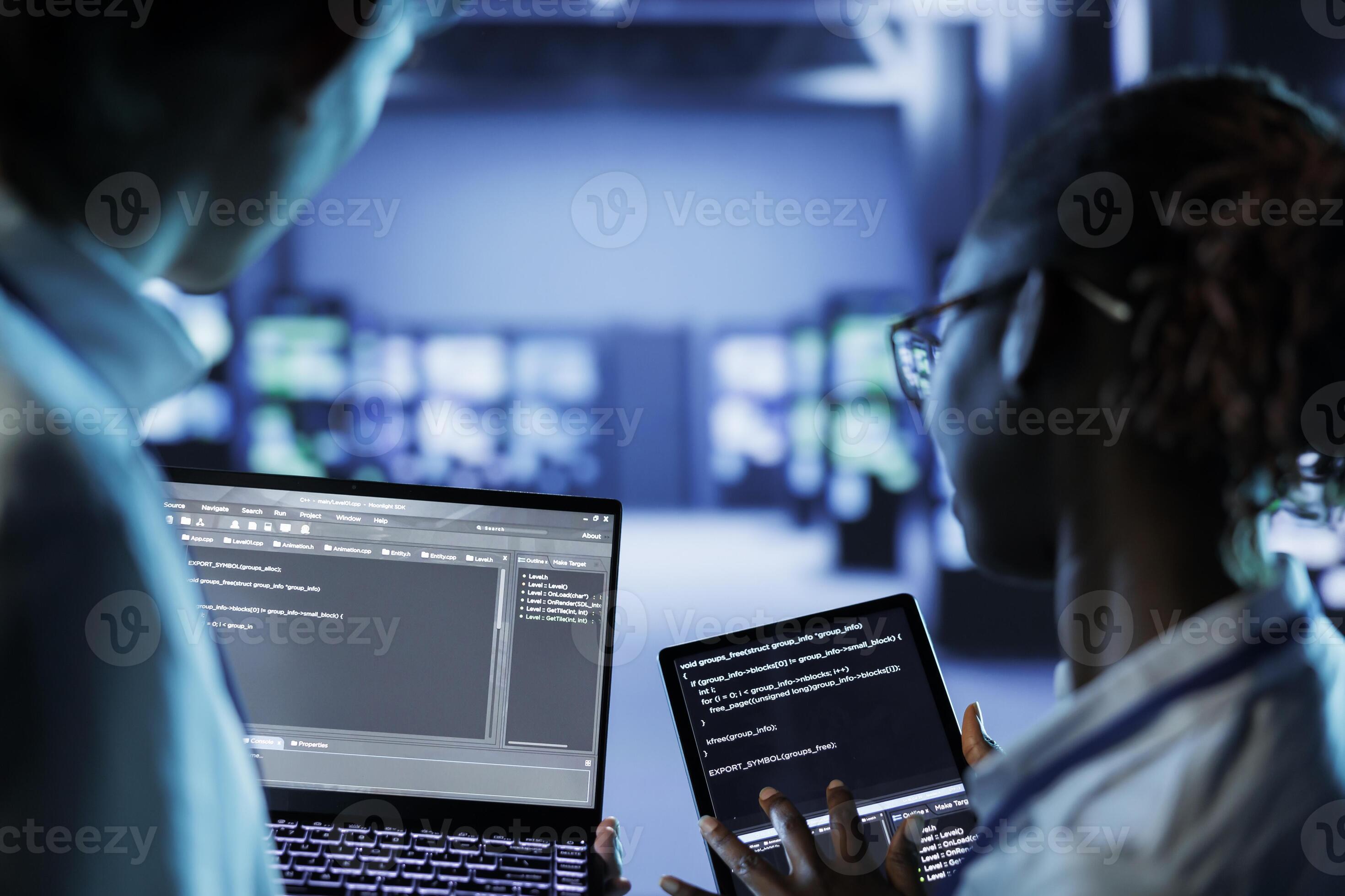 IT developers building firewall systems in server room housing advanced infrastructure. Licensed ...