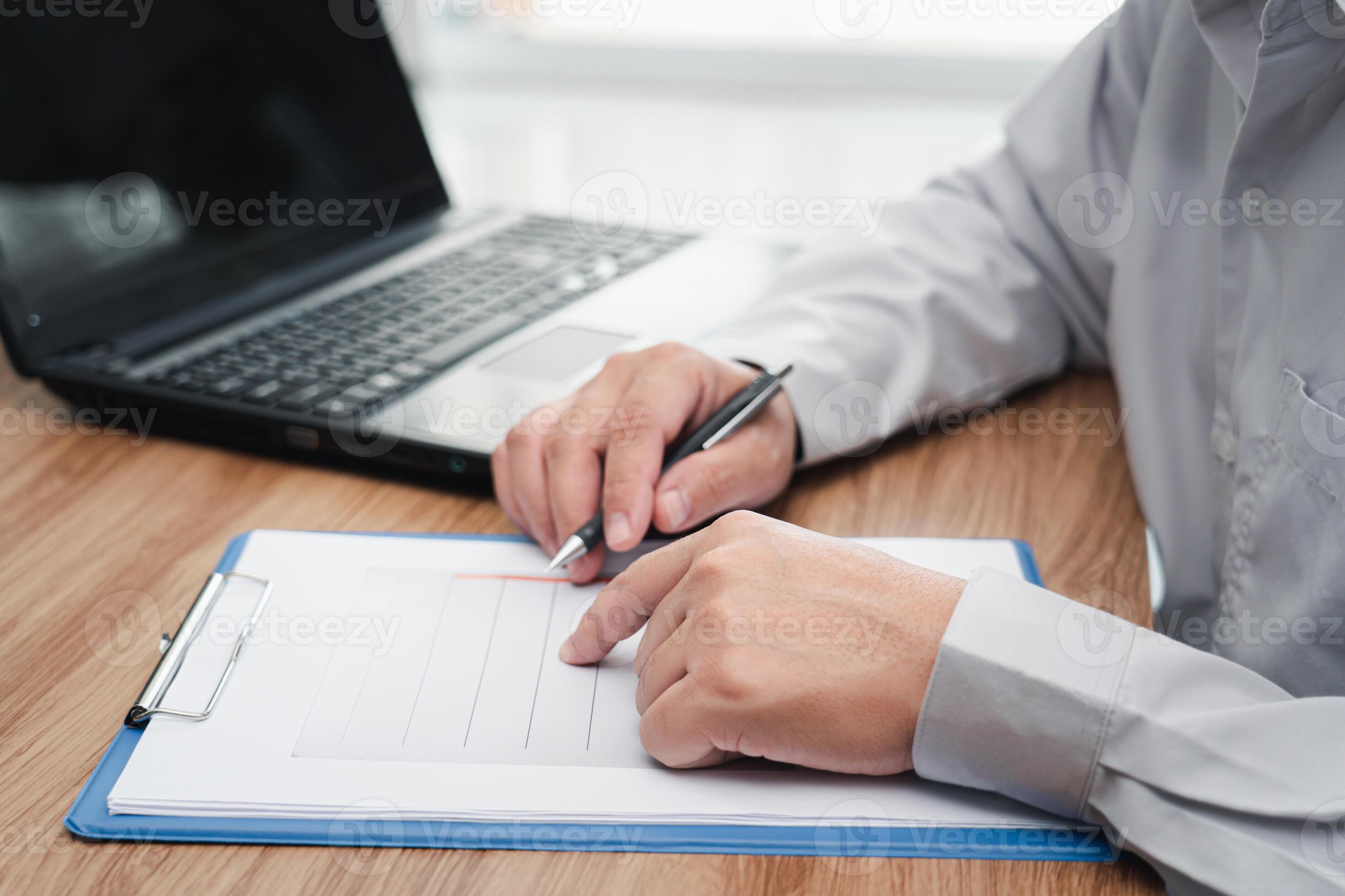 Business man working and analyzing on document data graph with laptop ...