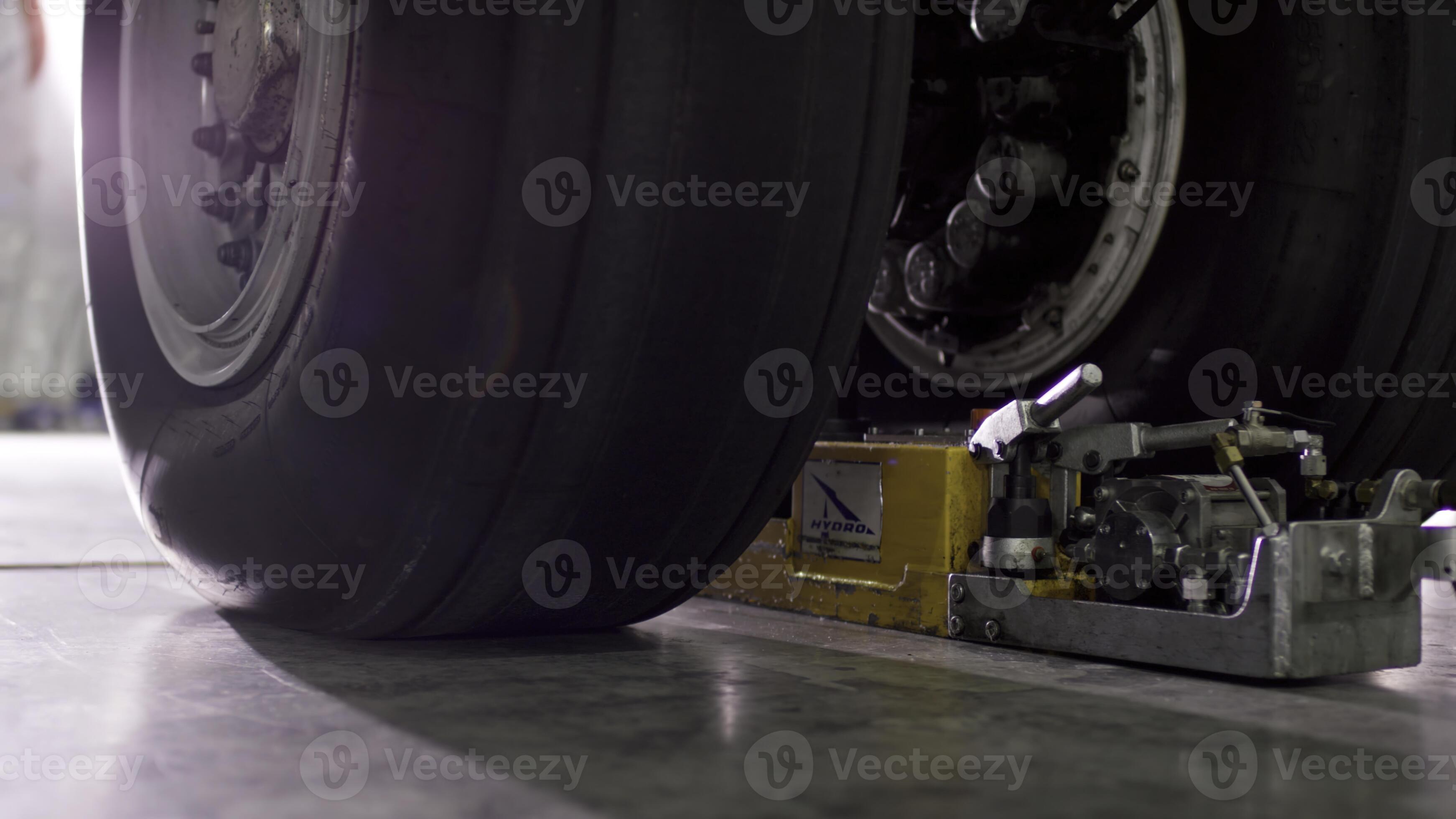 Airport worker checking chassis. Engine and chassis of the passenger airplane under heavy ...