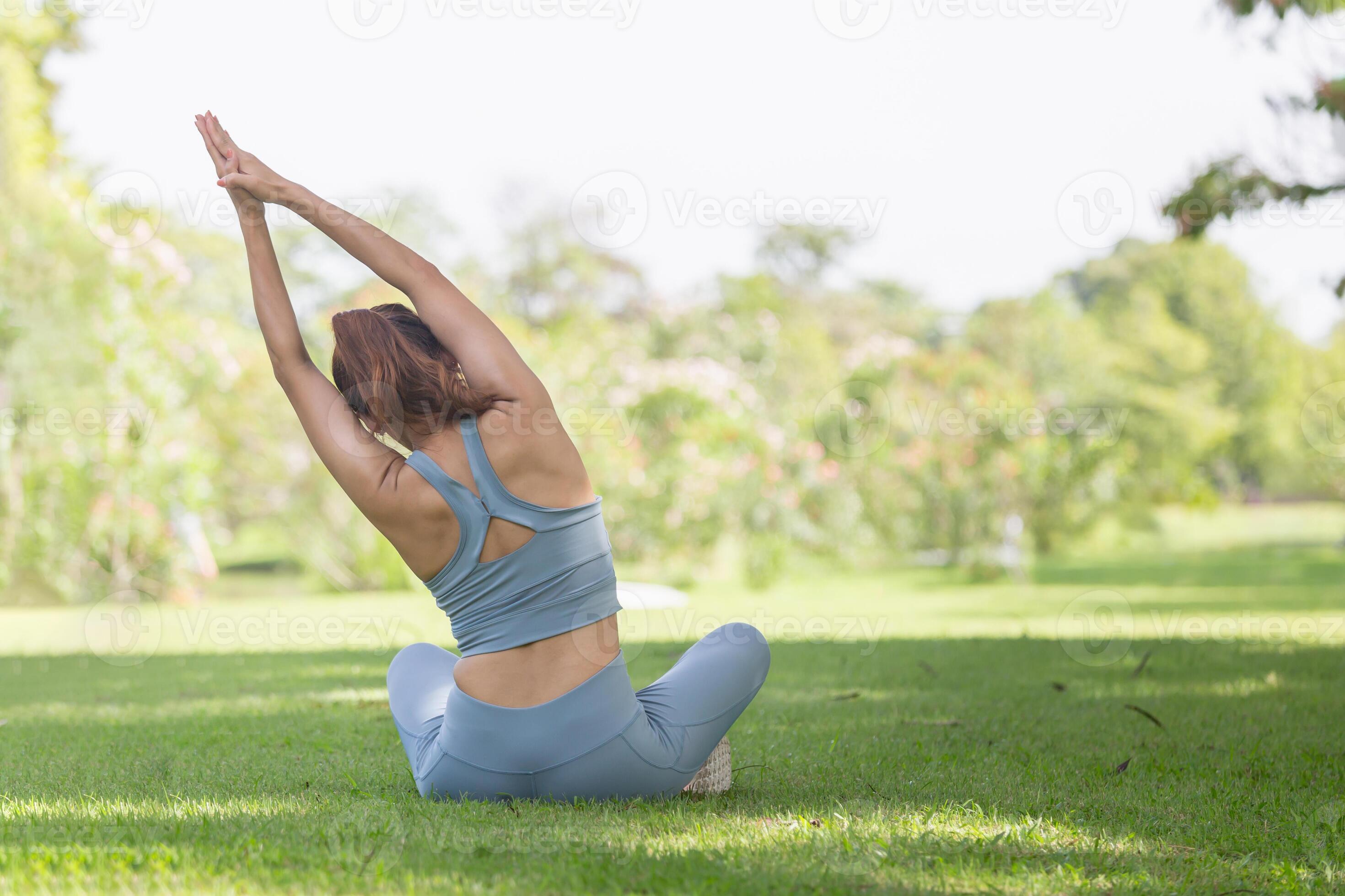 Back view of sports woman warming up outdoors, Asian woman doing yoga exercises, Fitness woman ...
