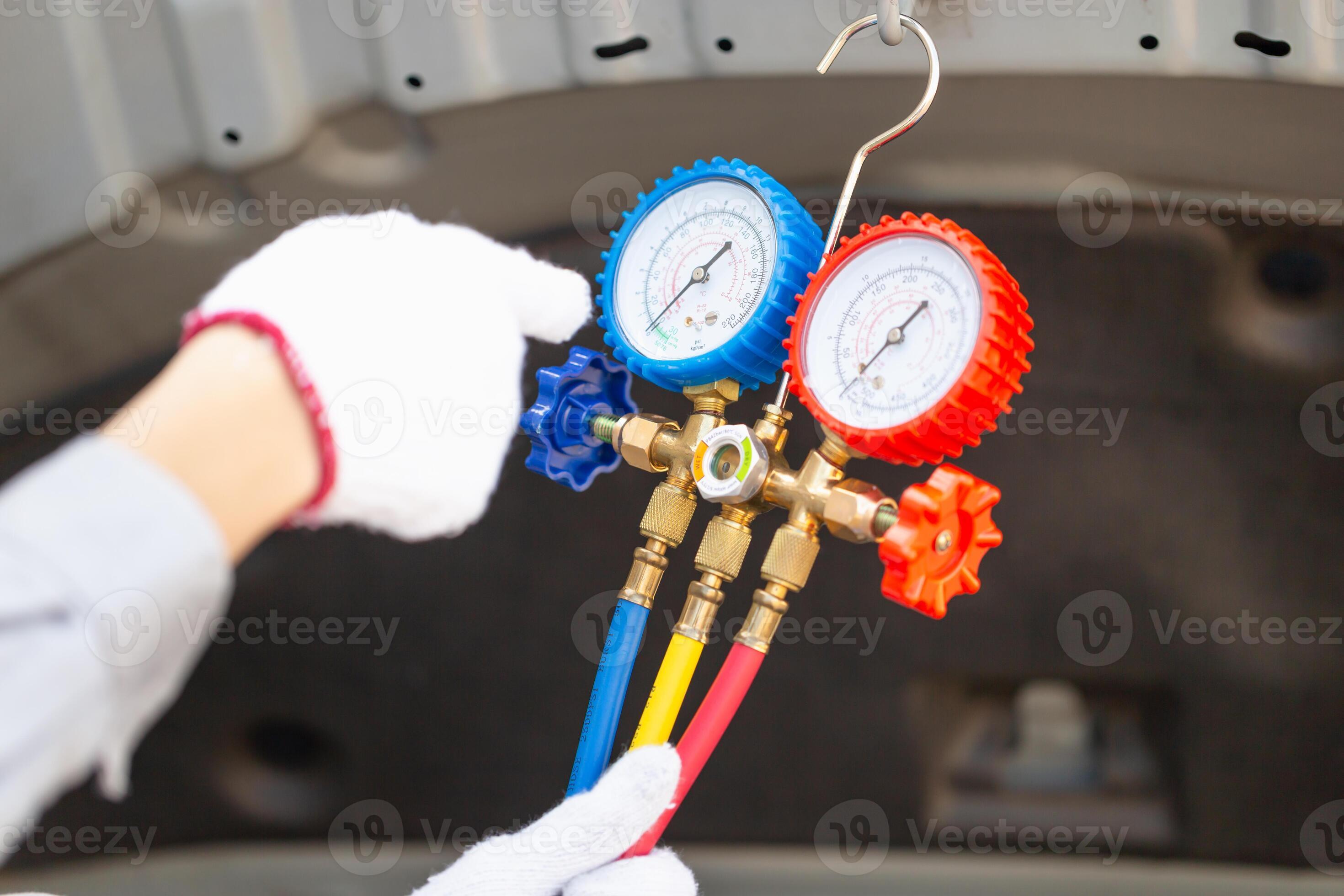 Technician checks car air conditioning system refrigerant recharge, Repairman with monitor tool ...