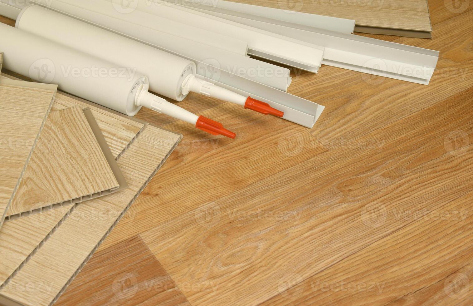 Set of items for PVC ceiling indoor works. Assembly adhesive bottles and PVC panels with plastic ...