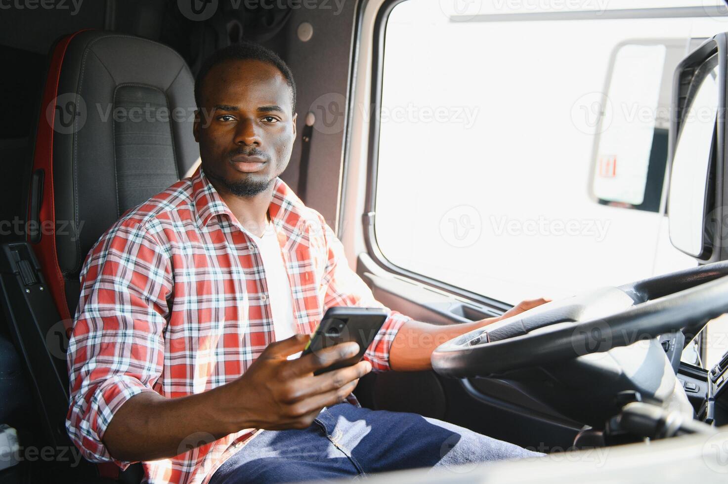 Young african american truck driver using mobile phone while driving ...