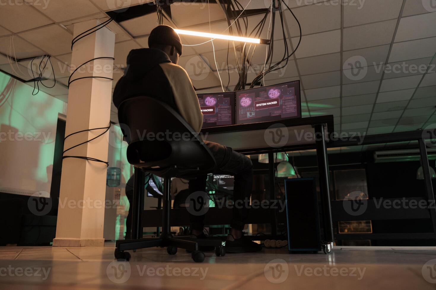 Professional hacker using encryption to break system, working on multiple monitors at night ...