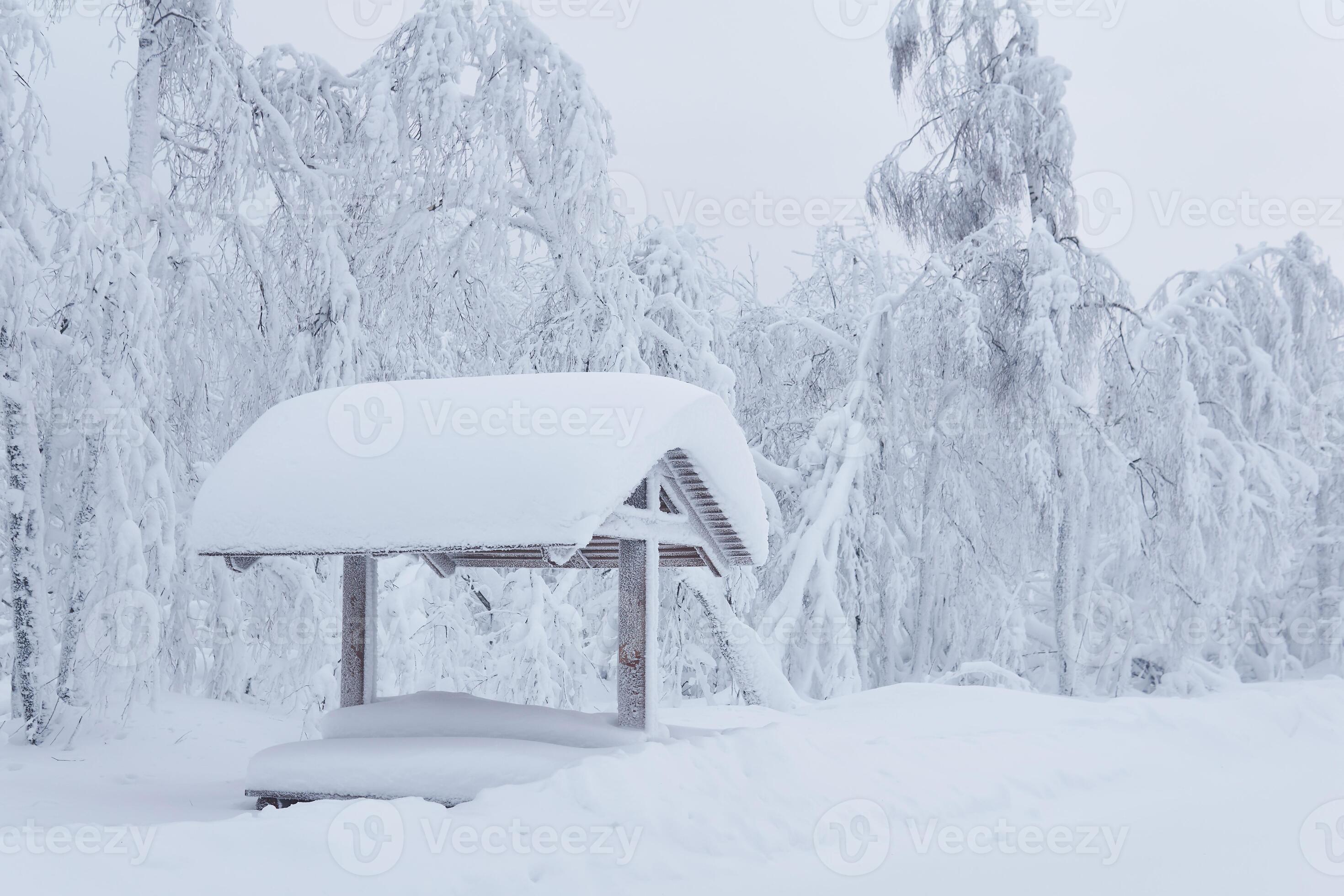 wooden gazebo with picnic table in a snowdrift after a heavy snowfall ...