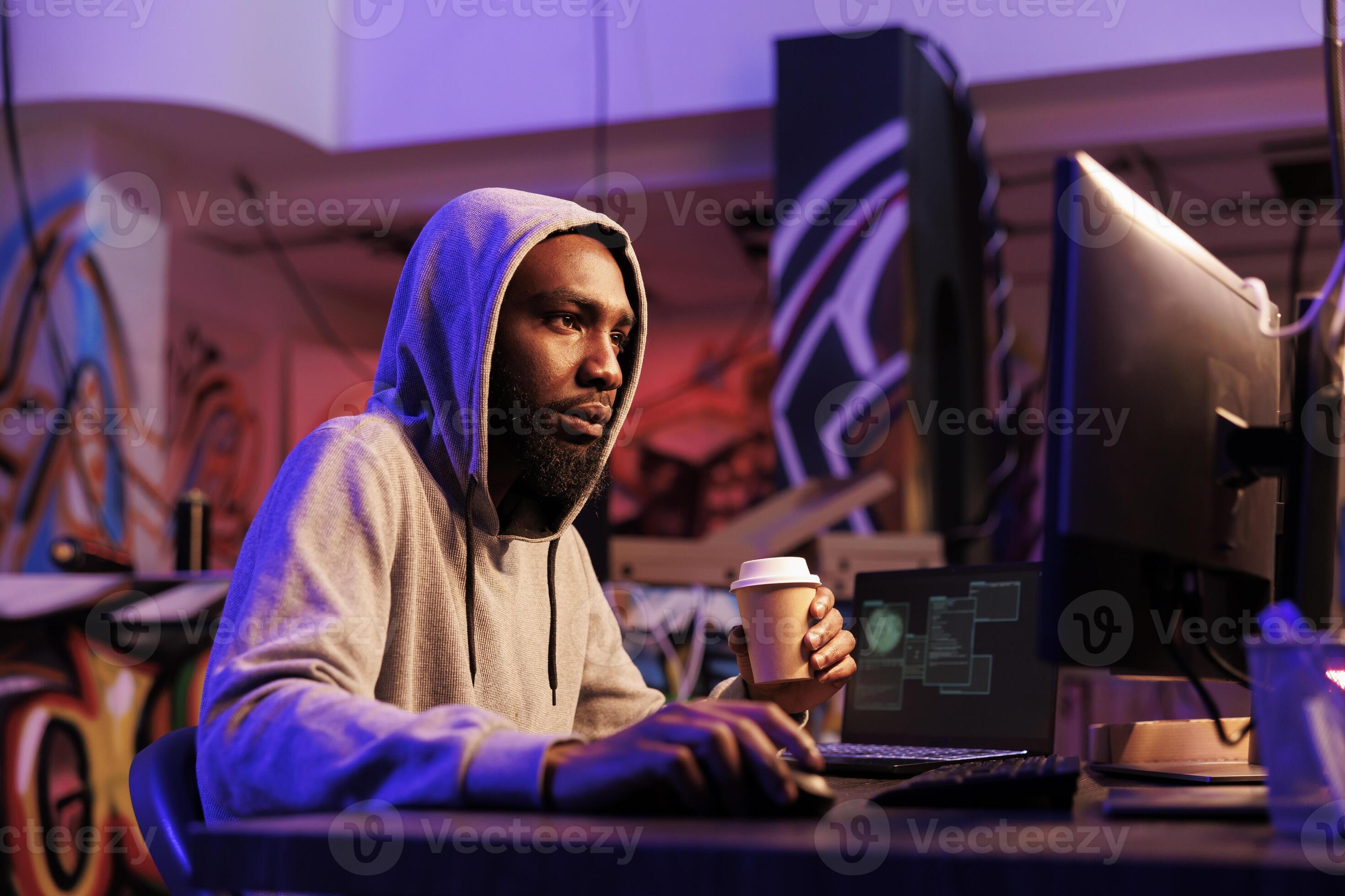 Hacker drinking coffee to go while doing criminal activity on computer ...