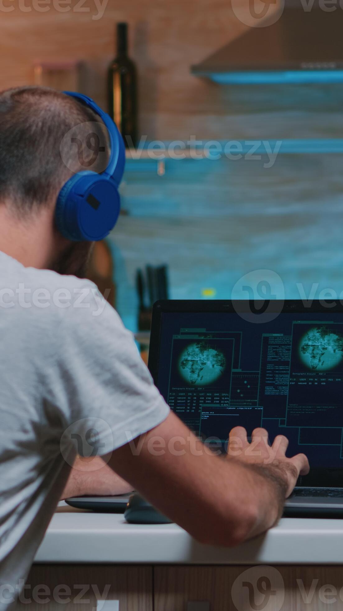 Man hacker with headset coding html and programming on screen laptop working from home in ...