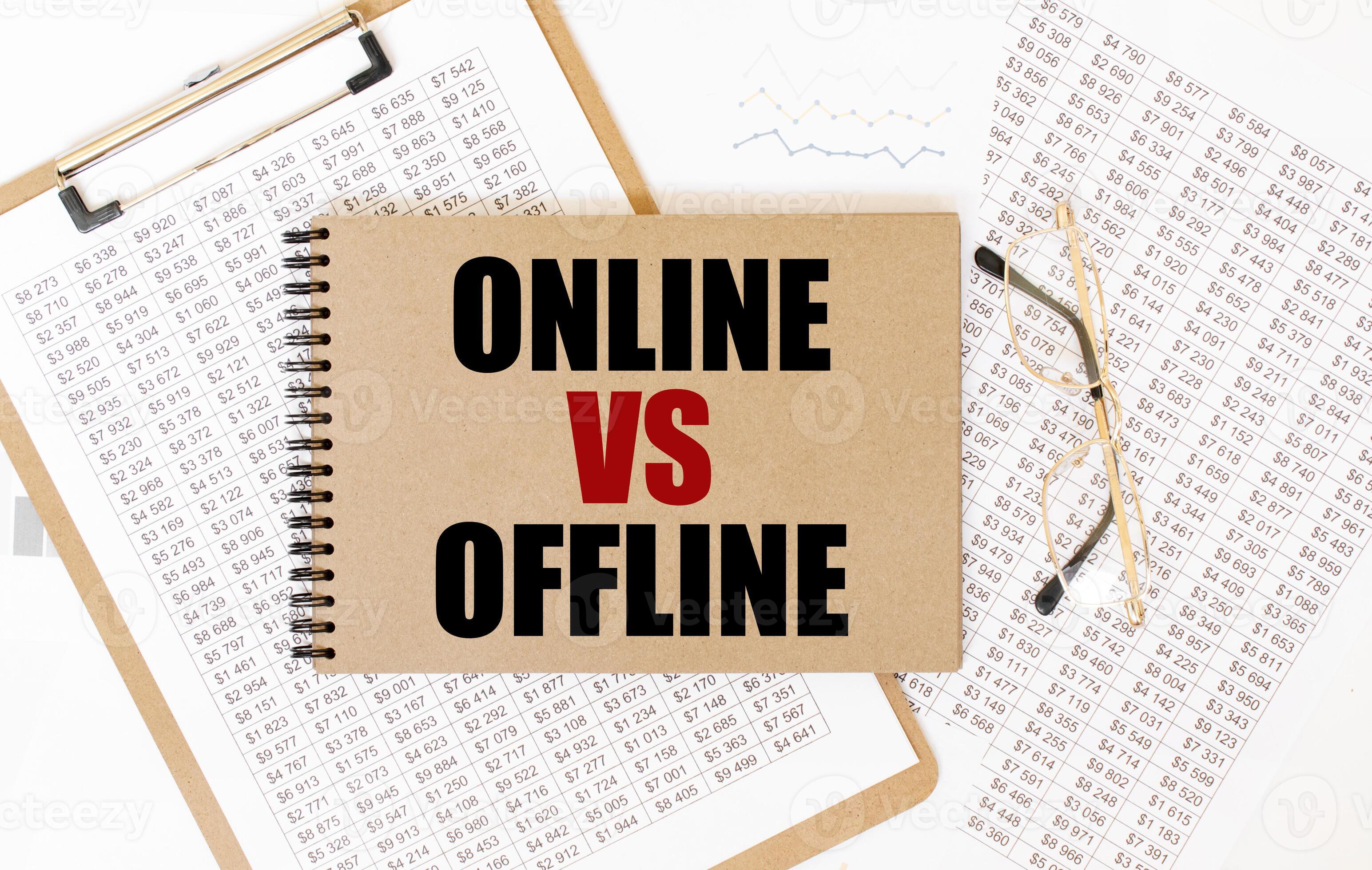 Craft colour notepad with text ONLINE VS OFFLINE. Notepad with eyeglasses and text documents ...