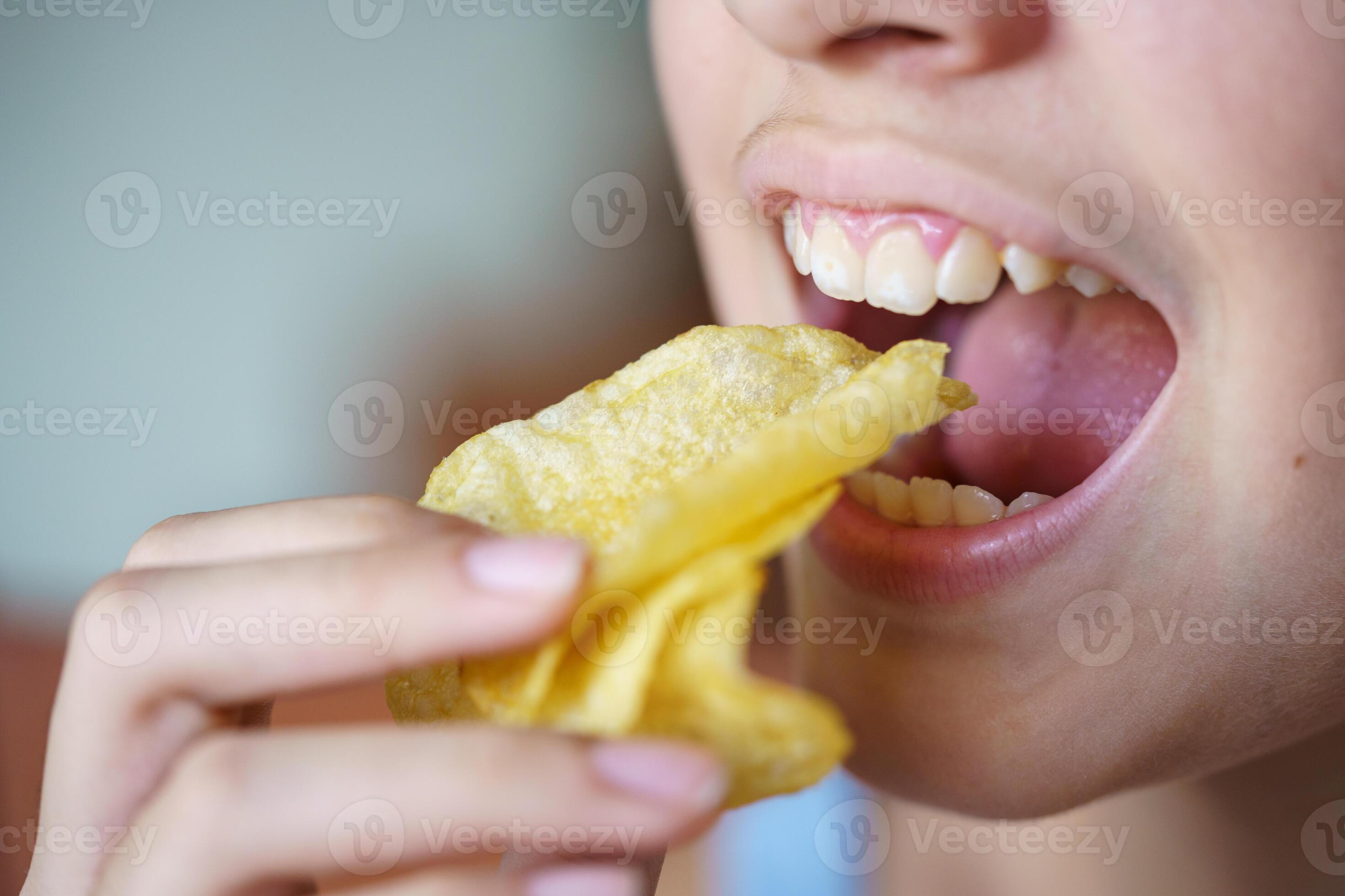 Unrecognizable teenage girl eating crunchy potato chips at home 40145824 Stock Photo at Vecteezy