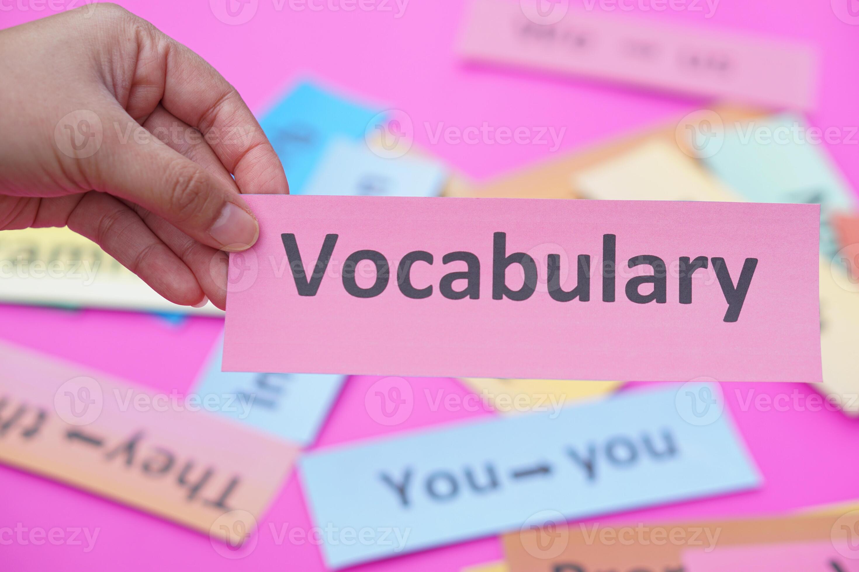 Close up hand holds paper card with text vocabulary. Concept, education ...