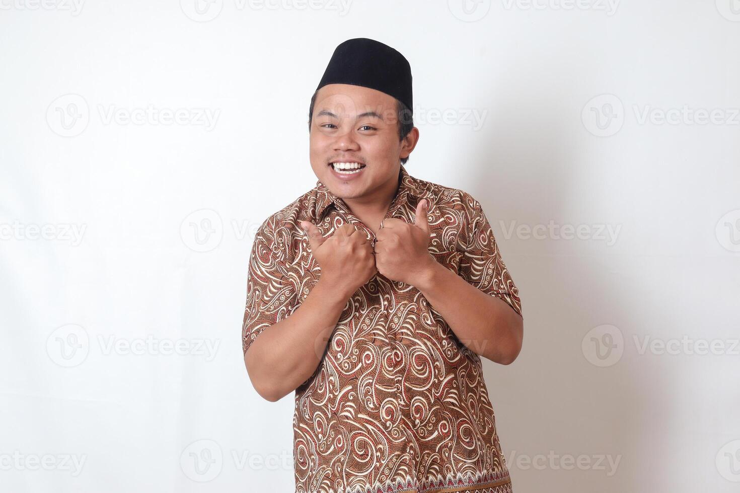 Portrait of excited Asian man wearing batik shirt and songkok smiling ...
