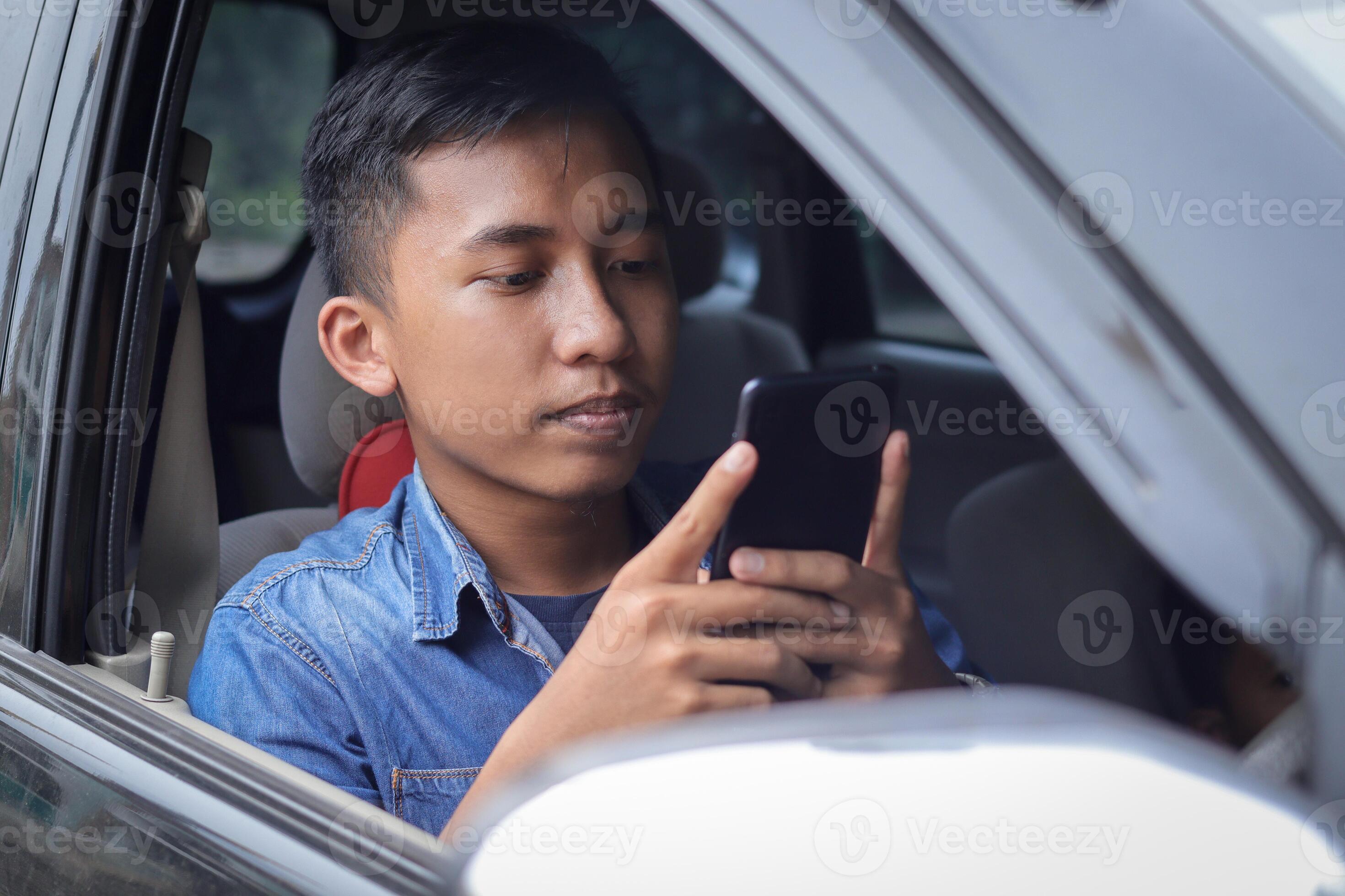 View of young Asian teenager holding and texting his phone while ...
