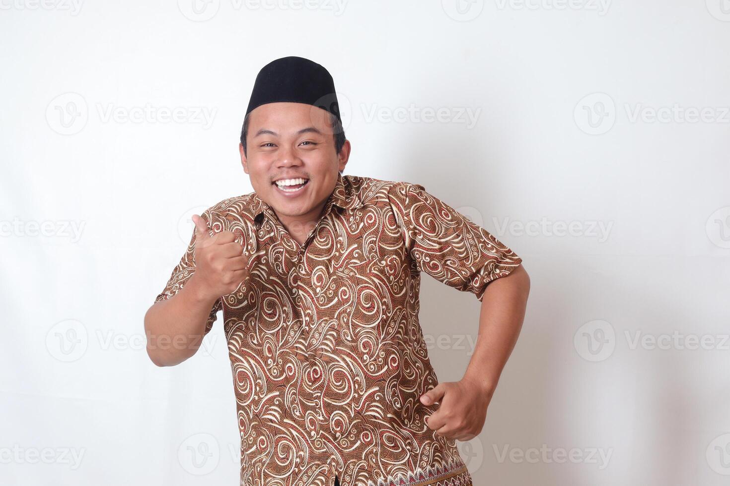 Portrait of excited Asian man wearing batik shirt and songkok smiling ...