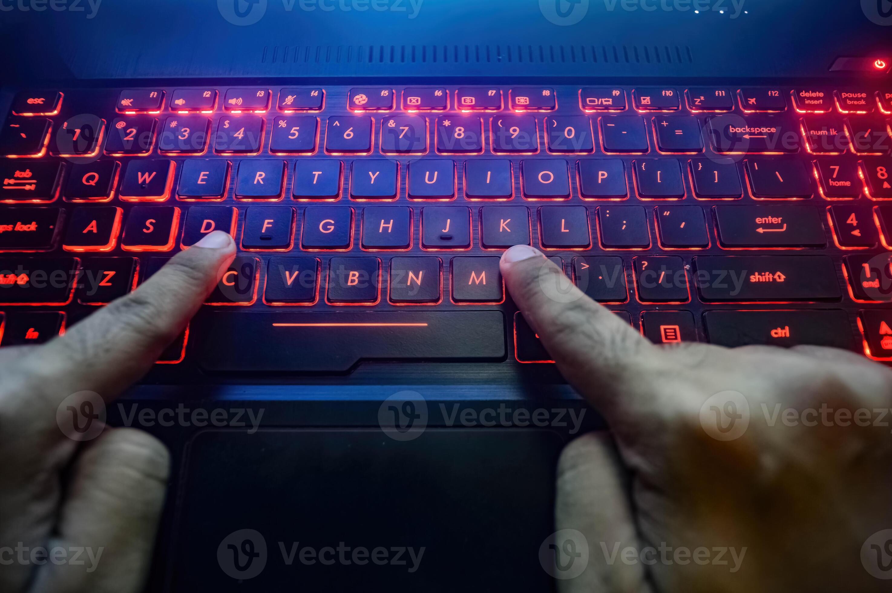 hands typing using both index fingers on a gaming laptop keyboard ...