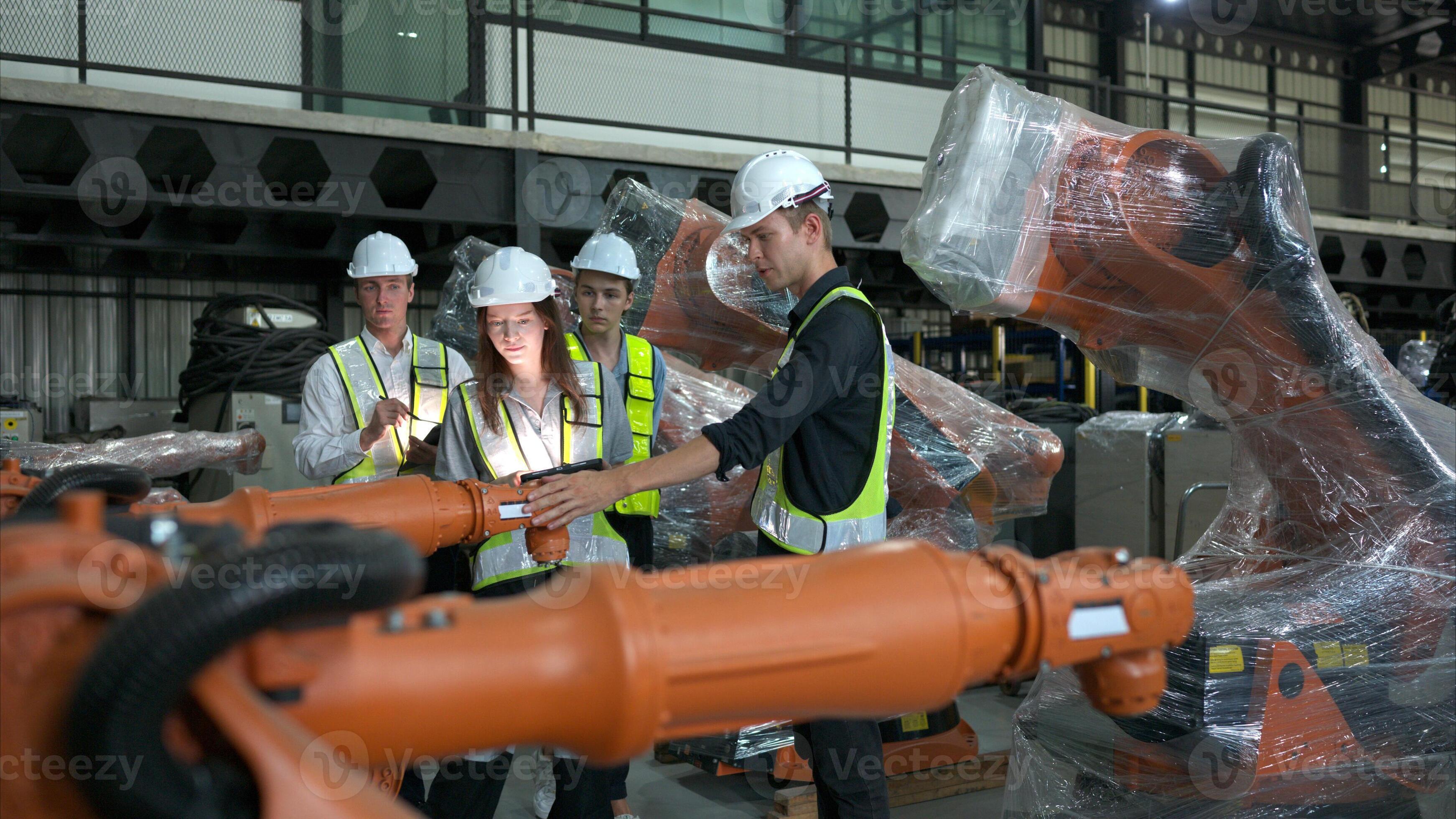 Group of engineers and technicians working together in a robotic arm ...