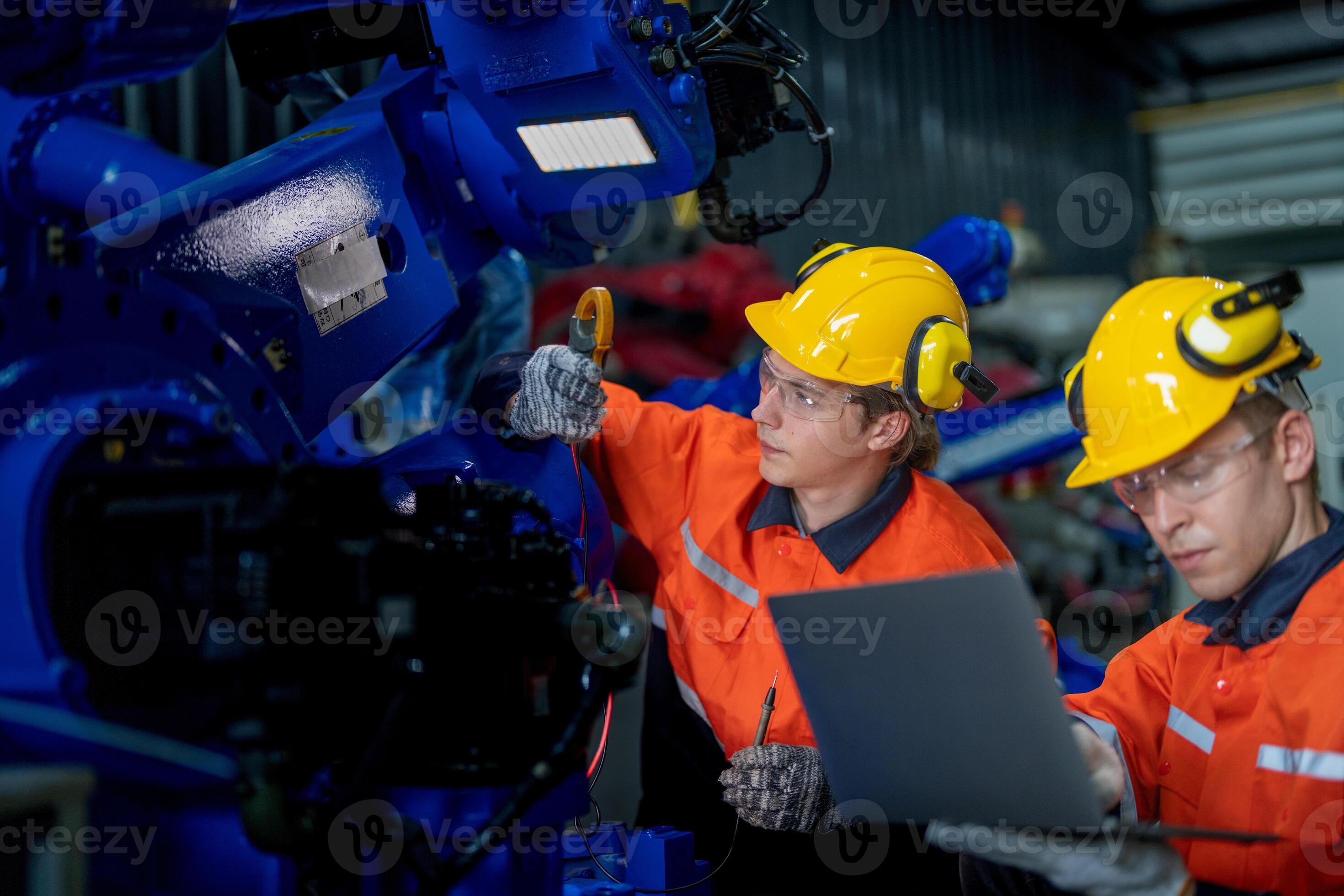 Factory engineers inspecting on machine with smart tablet. Worker works ...