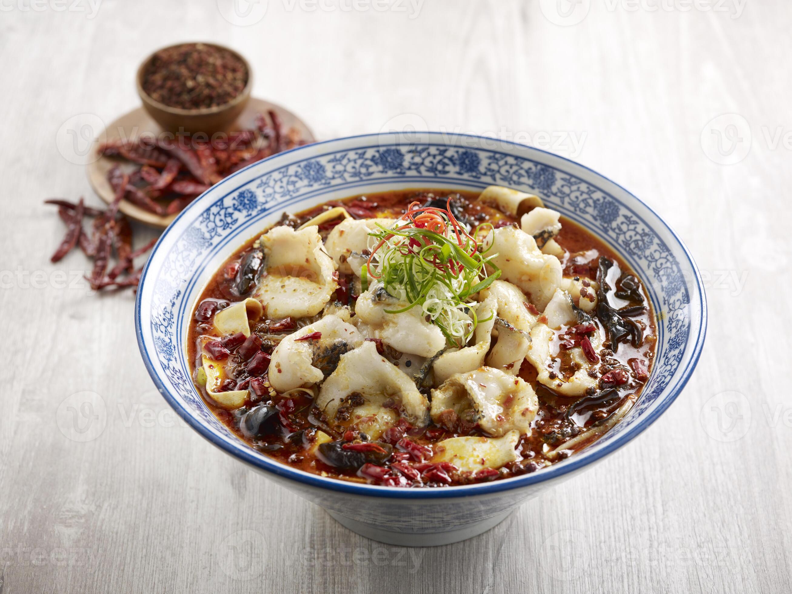 Poached Sliced Fish in Szechuan Style with chopsticks served in a dish isolated on mat side view ...