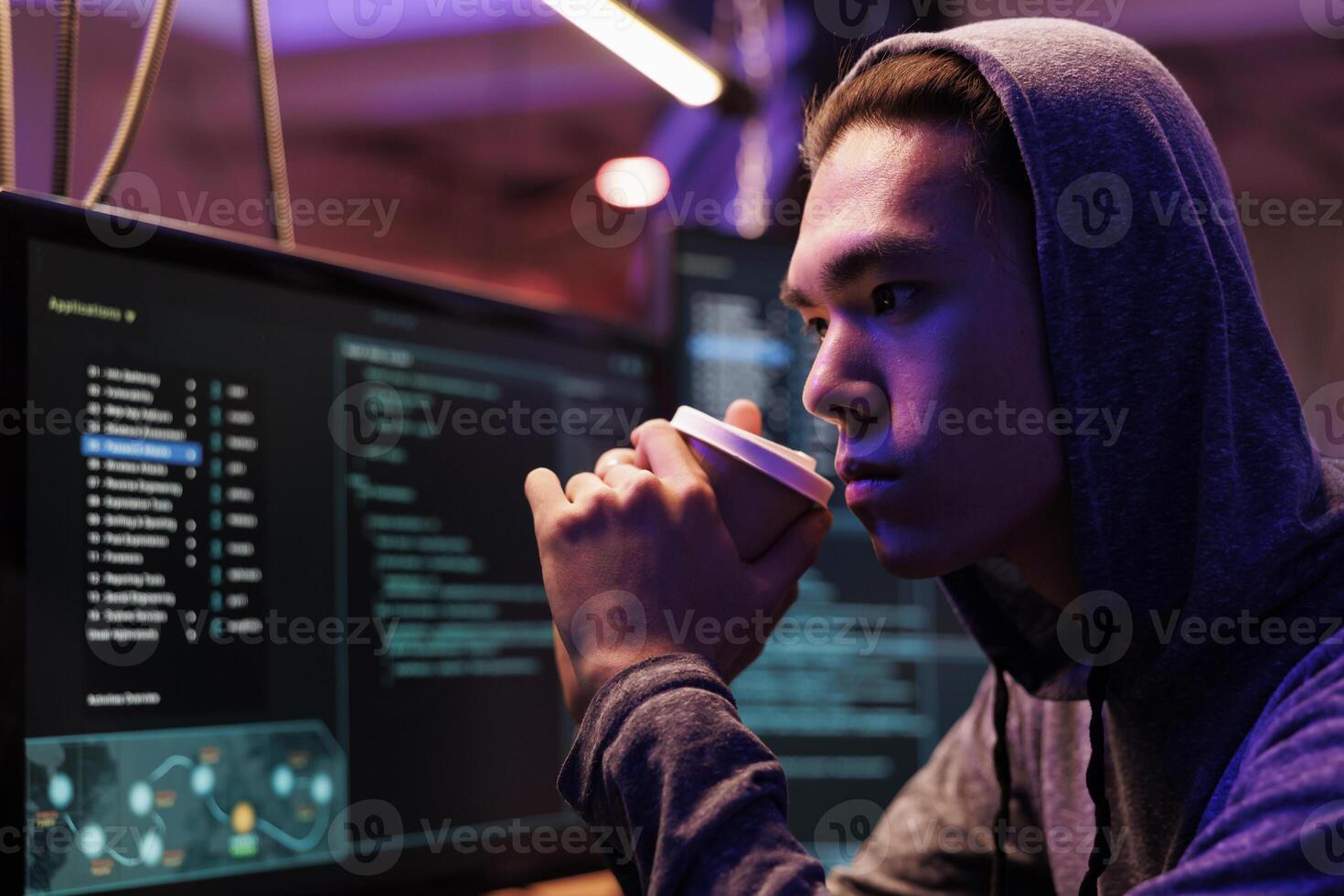 Asian Hacker Drinking Coffee And Breaking Into Database Using Spyware