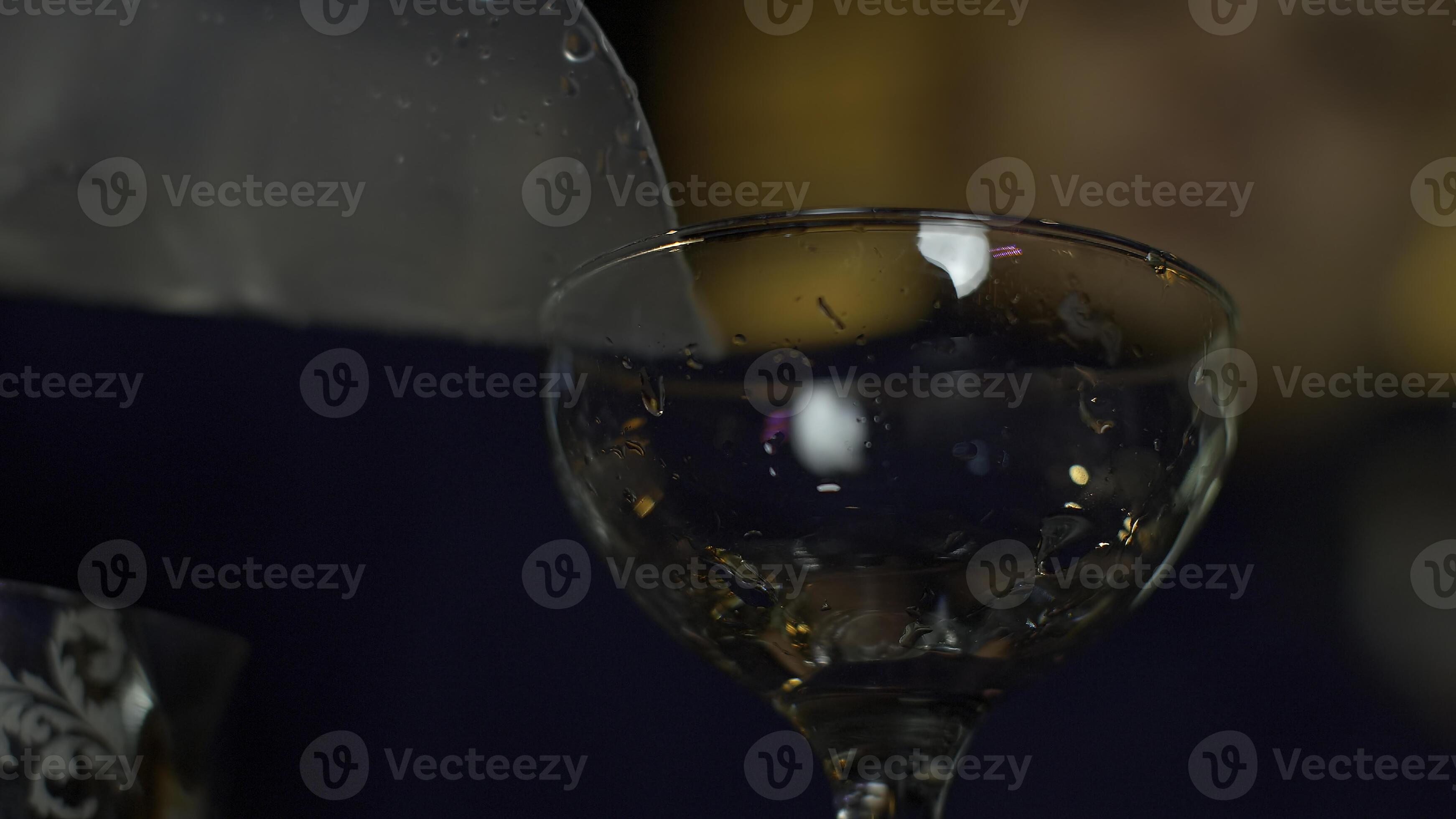 Close up of bartender putting large cubes of ice nto the empty vintage glass. Media ...