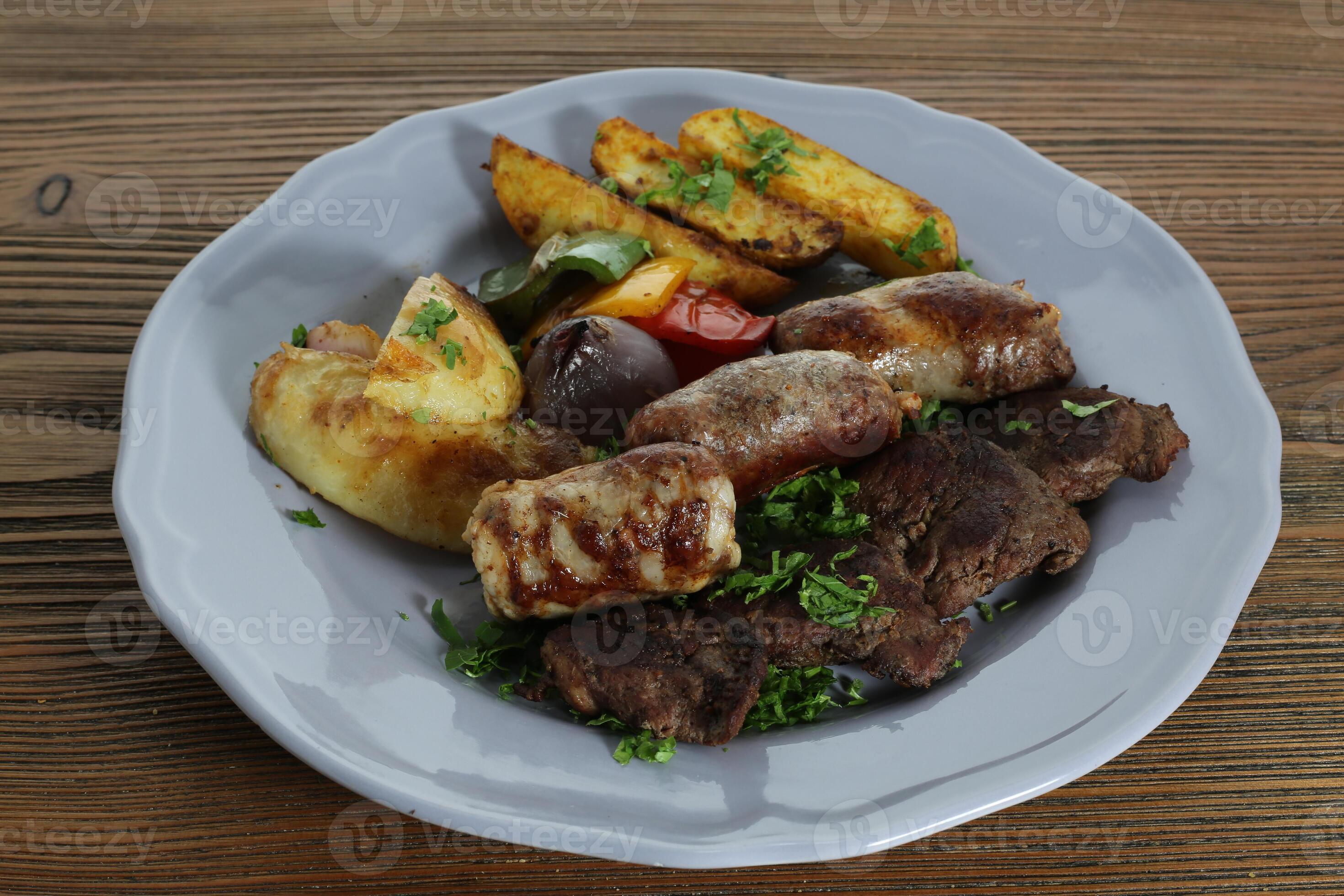 beef tikka kabab and sausage with potato veggies served in dish ...