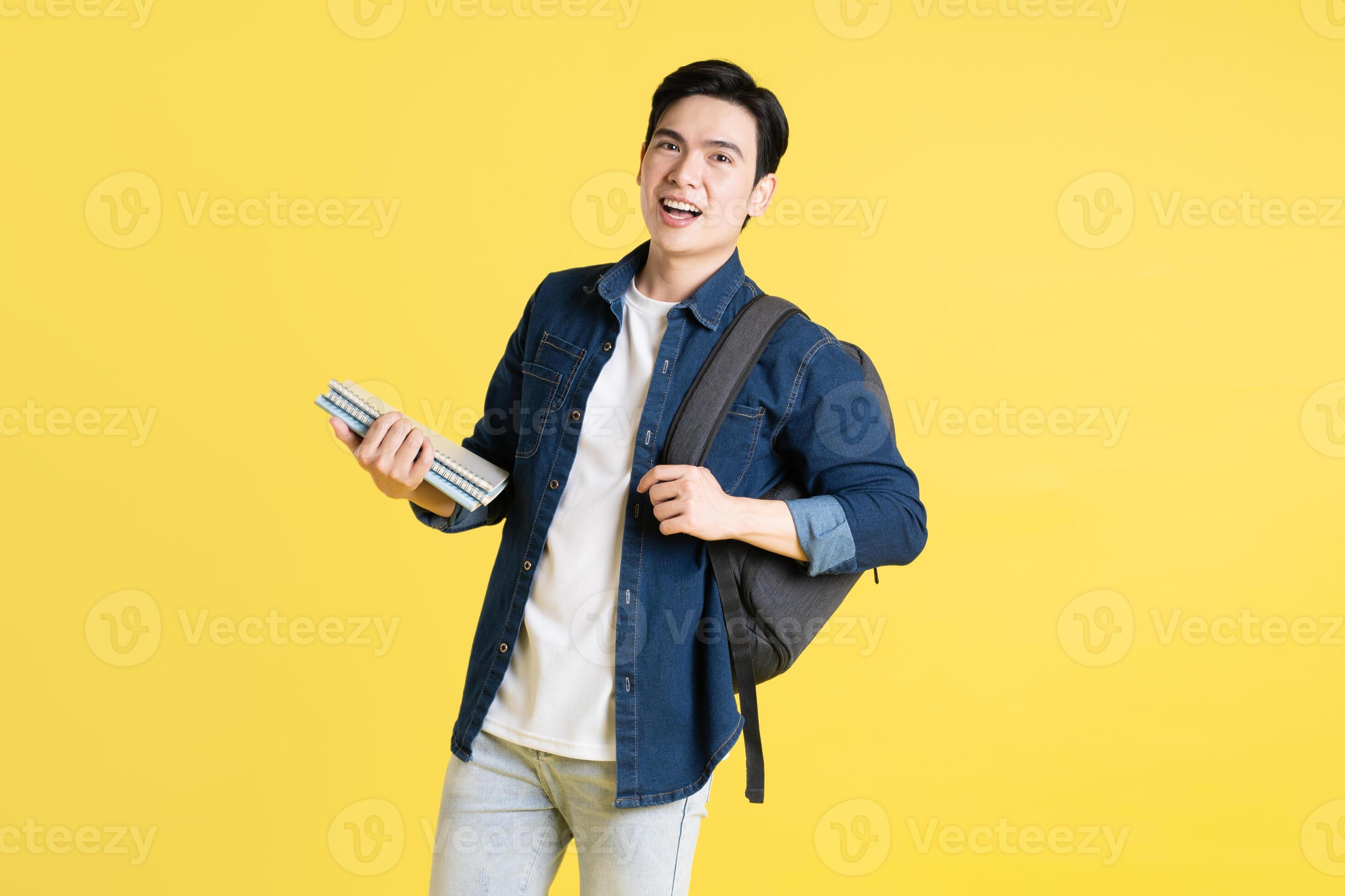 Portrait of Asian male student posing on yellow background 43223678 ...