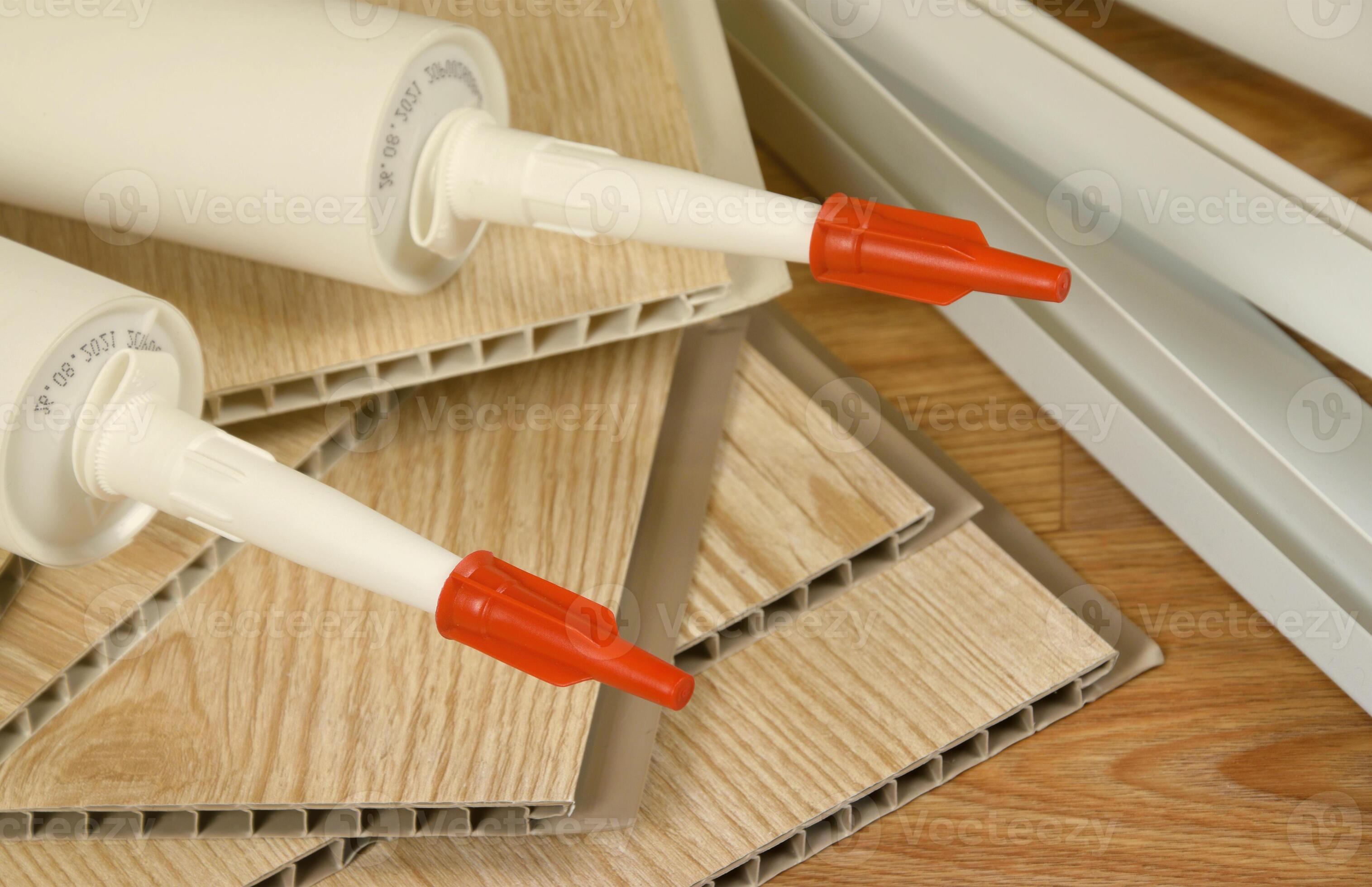 Set of items for PVC ceiling indoor works. Assembly adhesive bottles and PVC panels with plastic ...