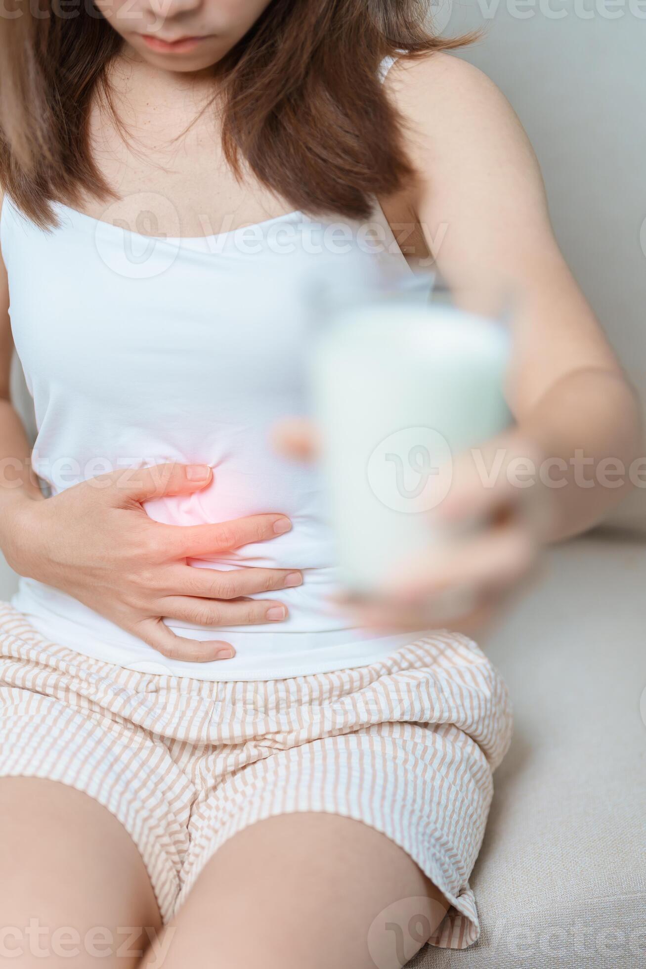 Lactose intolerance and Milk allergy concept. woman hold Milk glass and having abdominal cramps ...