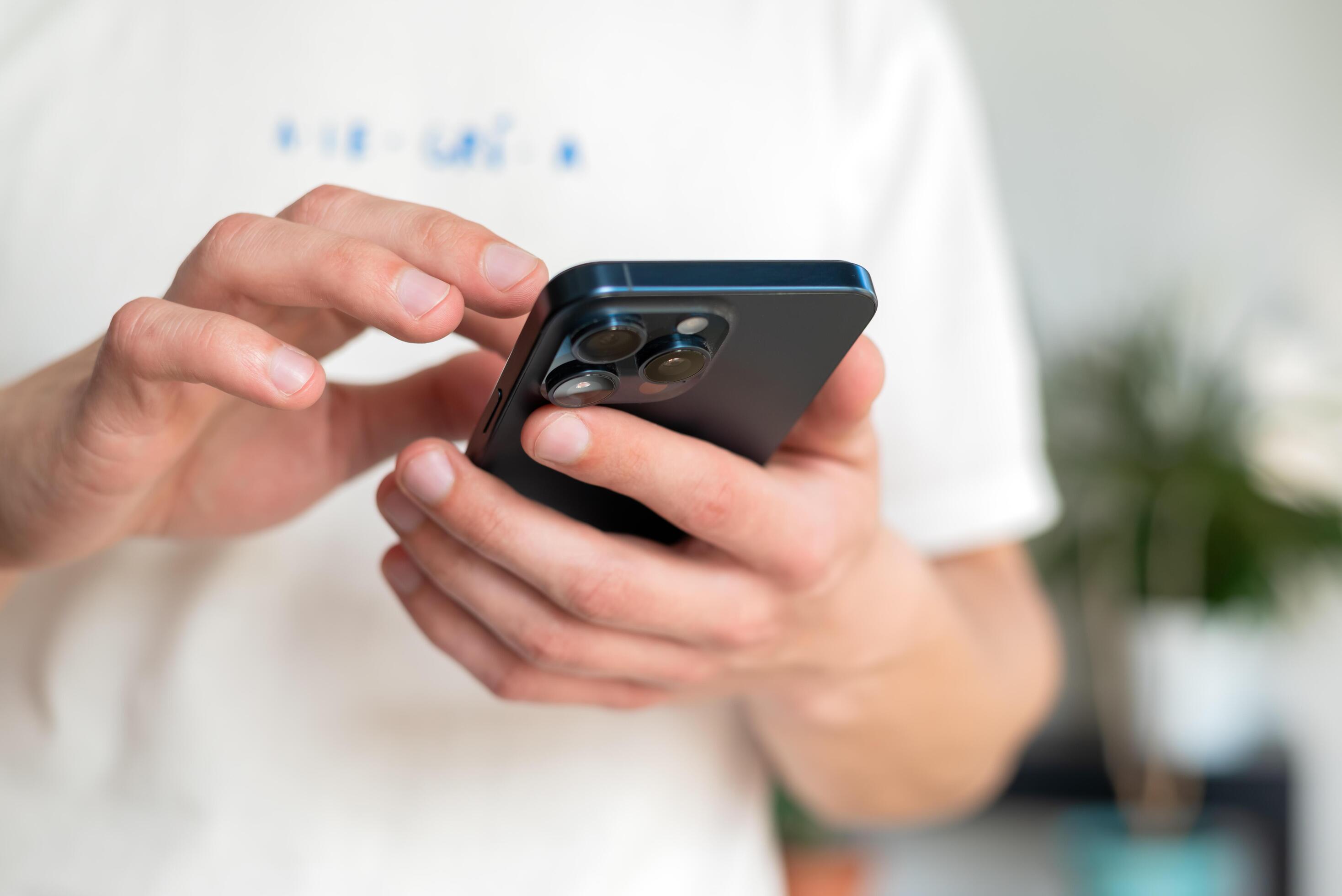 Kyiv, Ukraine. April 25, 2024. Man using a new mobile phone, iphone 15 smartphone close-up ...