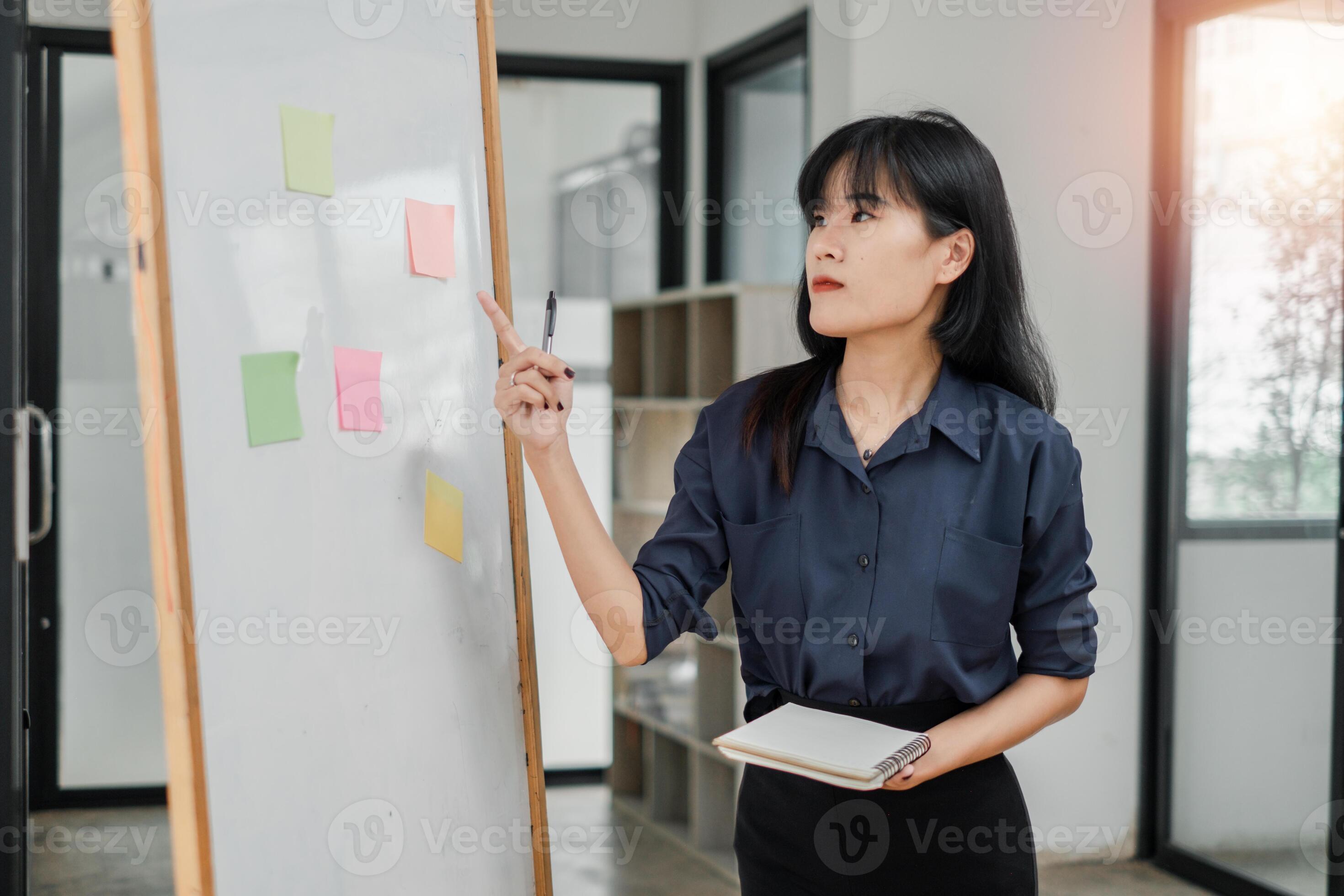 Businesswoman Using Sticky Notes For Brainstorming And Organizing Tasks