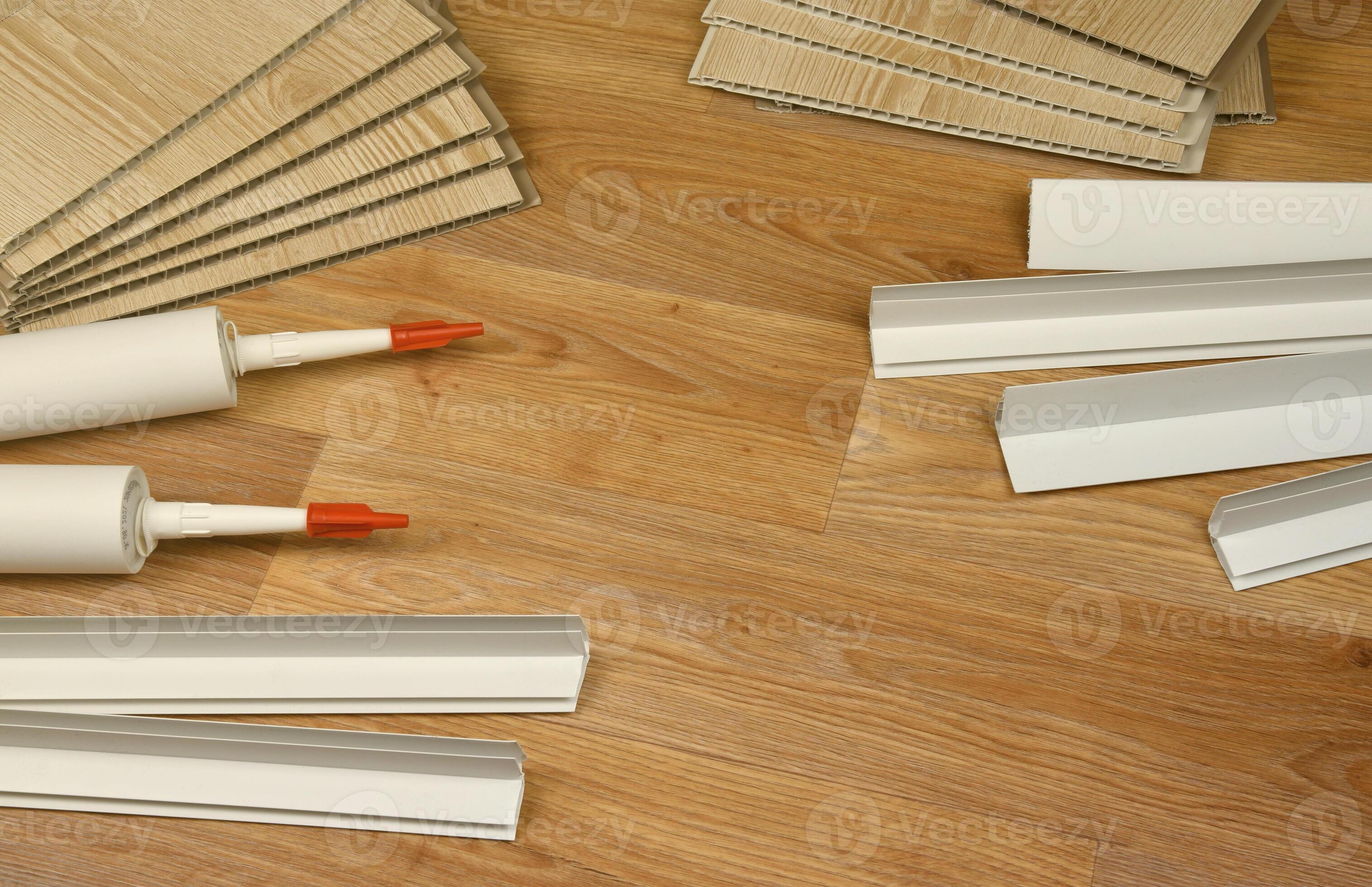 Set of items for PVC ceiling indoor works. Assembly adhesive bottles and PVC panels with plastic ...