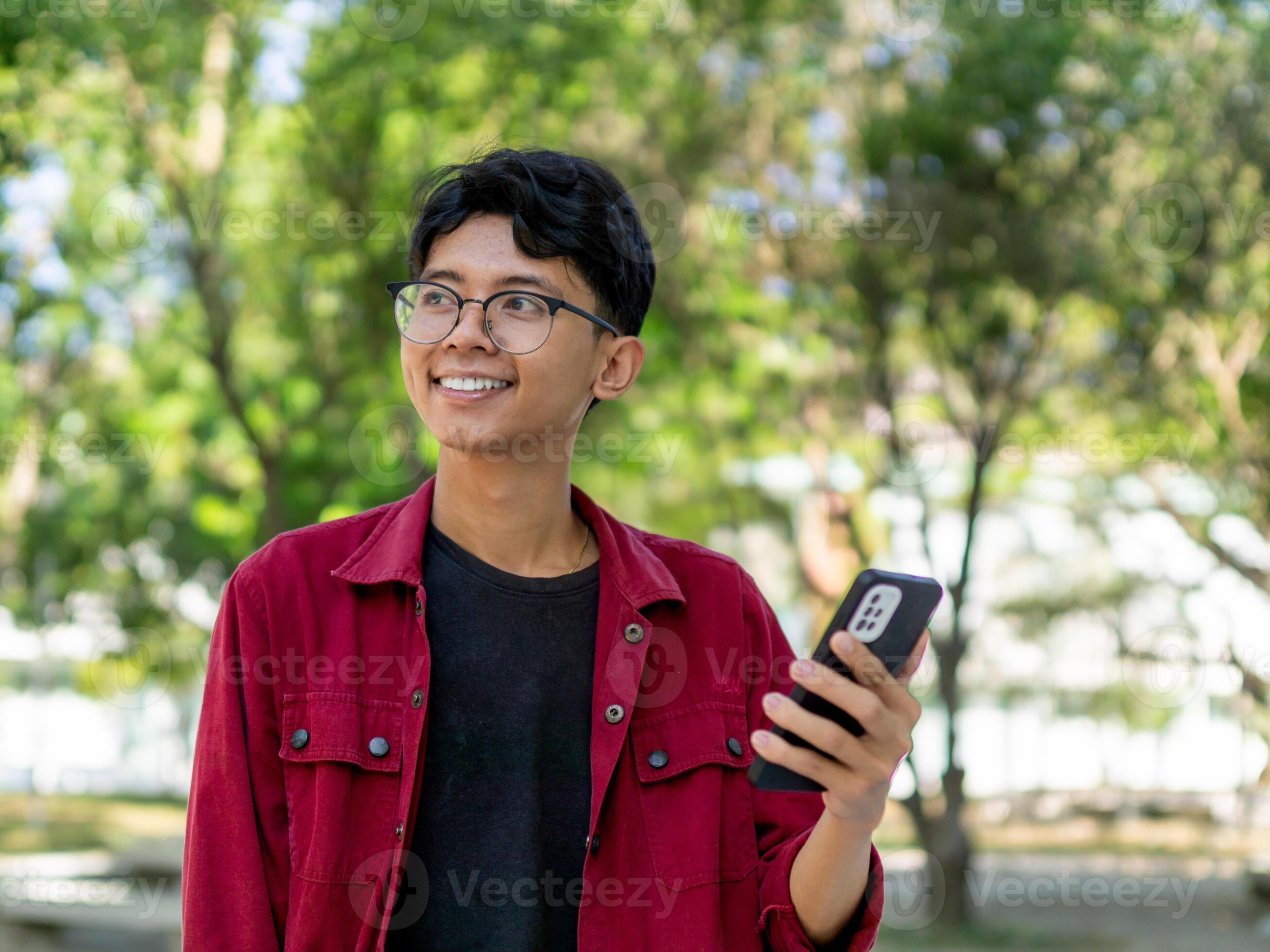Portrait Of Asian Man Smiling While Holding His Phone Man With Red