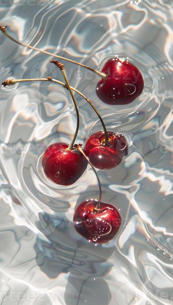A photo of floating red cherries in water with a beautiful light reflecting on the surface ...