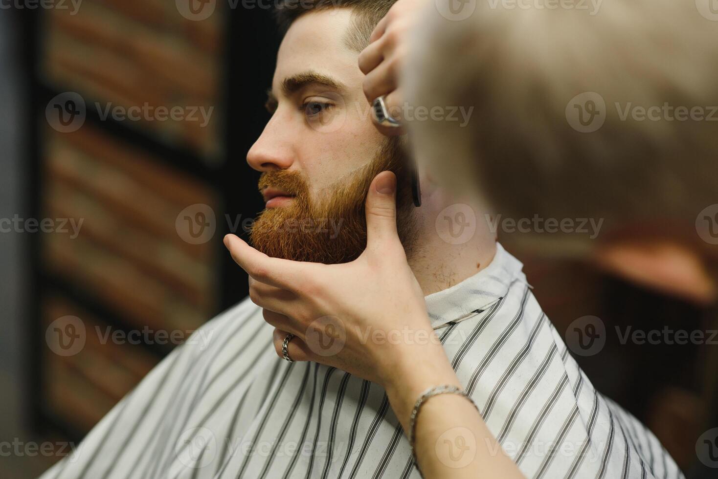 Close up image of barber shaving a man with a sharp steel razor ...