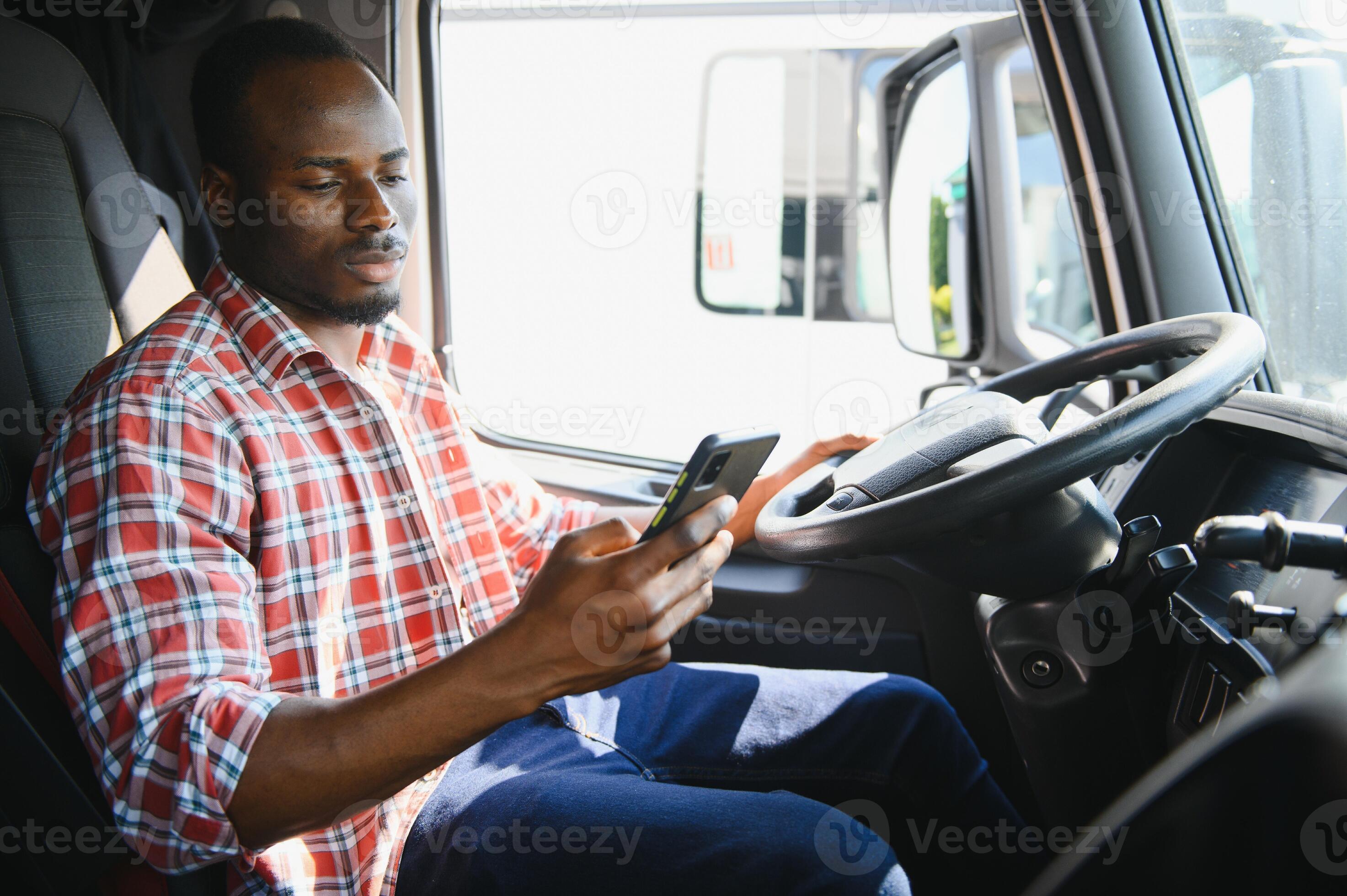 Young african american truck driver using mobile phone while driving ... Young african american truck driver using mobile phone while driving ...