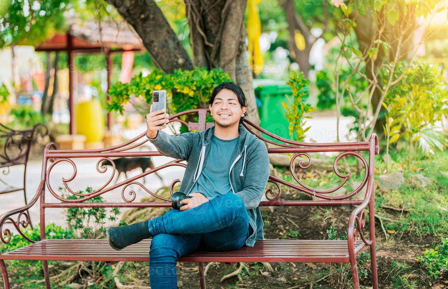 Relaxed Guy Taking A Selfie Sitting On A Bench At Sunset Smiling Man Sitting On A Bench Taking
