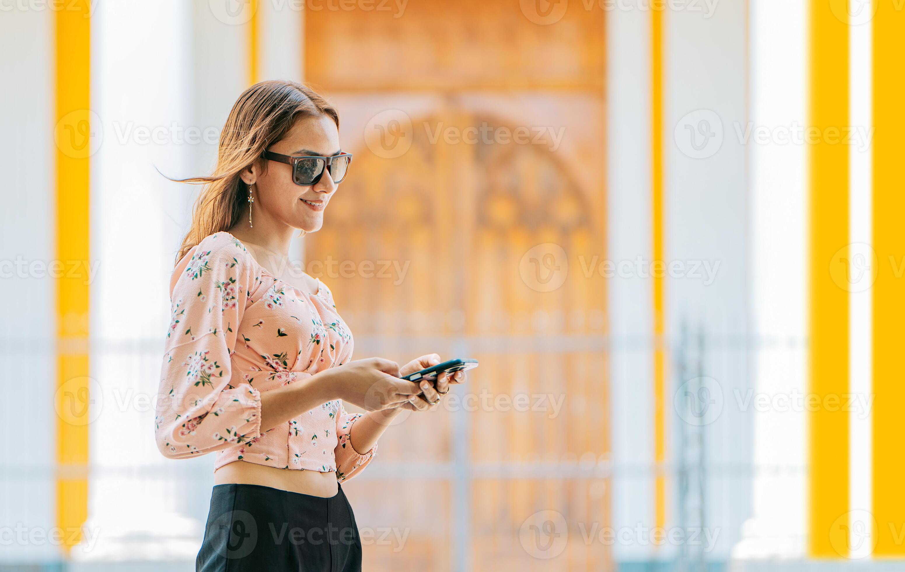 Happy tourist girl texting with phone on the street of Granada ...