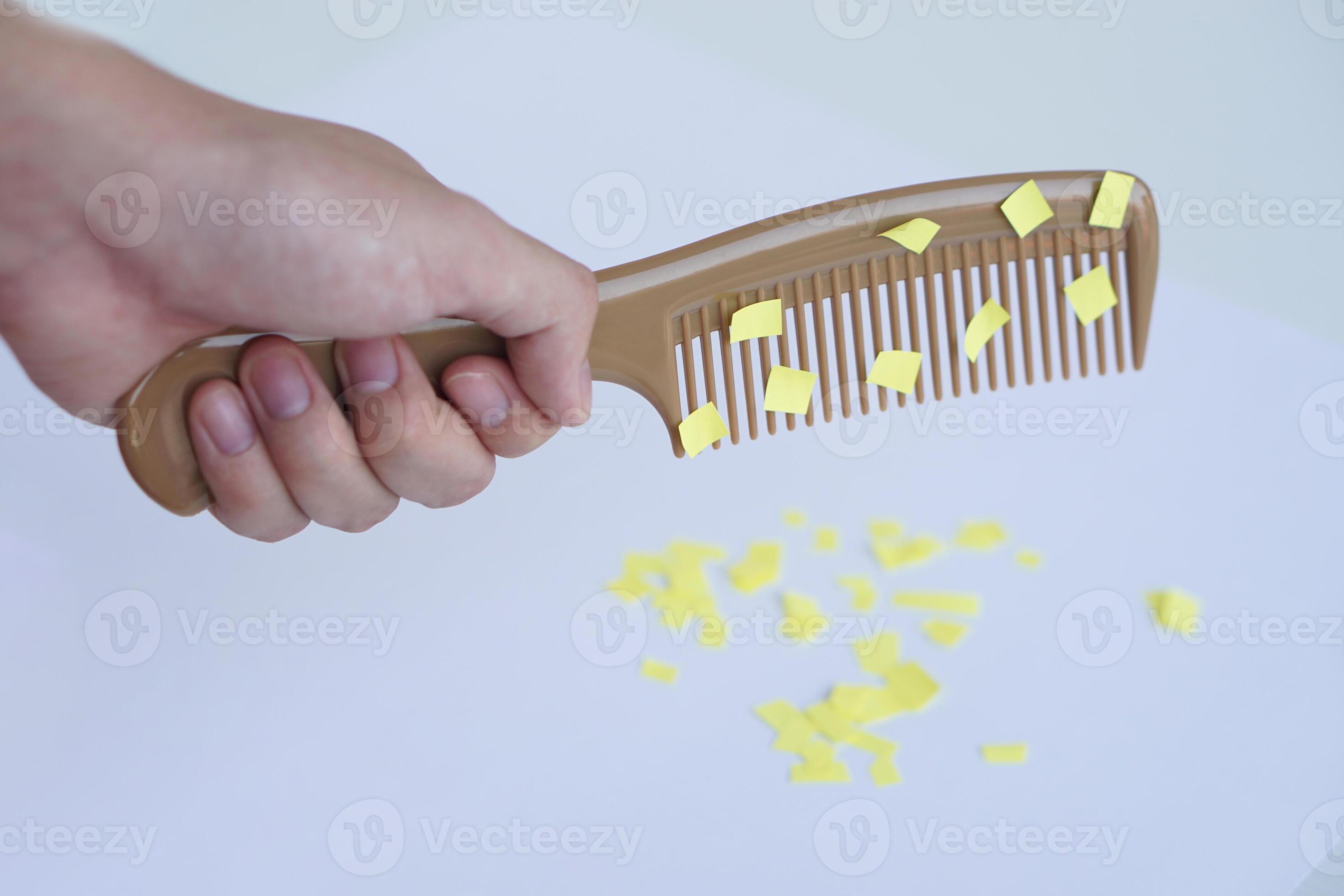 Hand holds comb and small pieces of paper. Equipment, prepared to do experiment about static ...