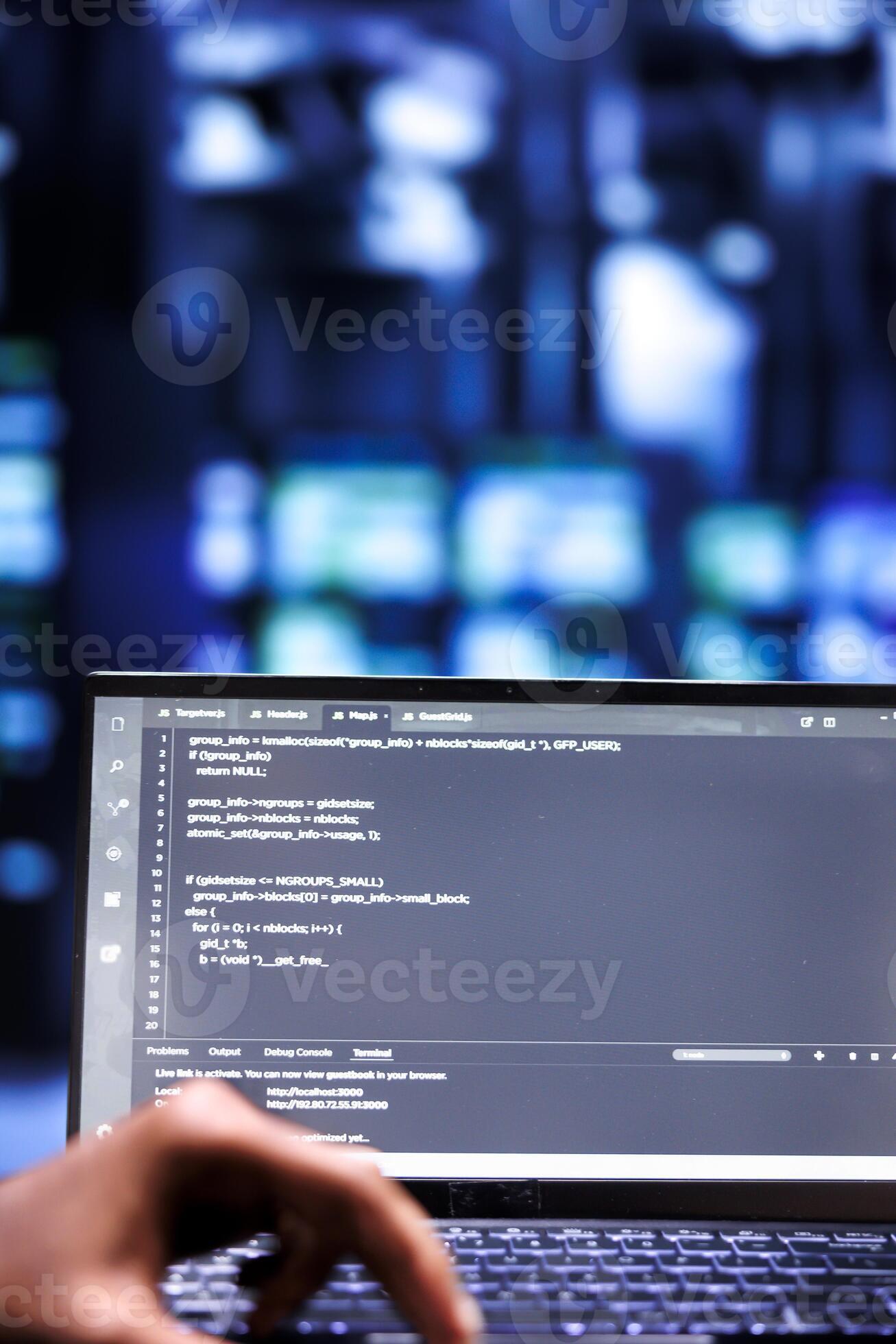 Computer scientists updating rackmounts, writing lines of code on laptop terminal, close up ...