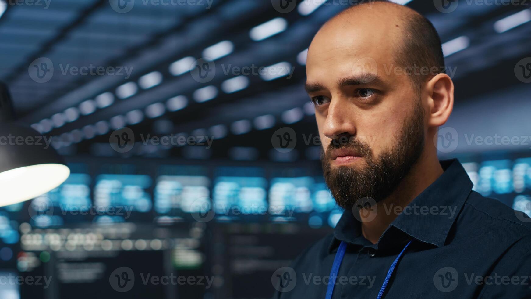 Close up on programmer in server farm safeguarding data from intruding hackers. Developer ...