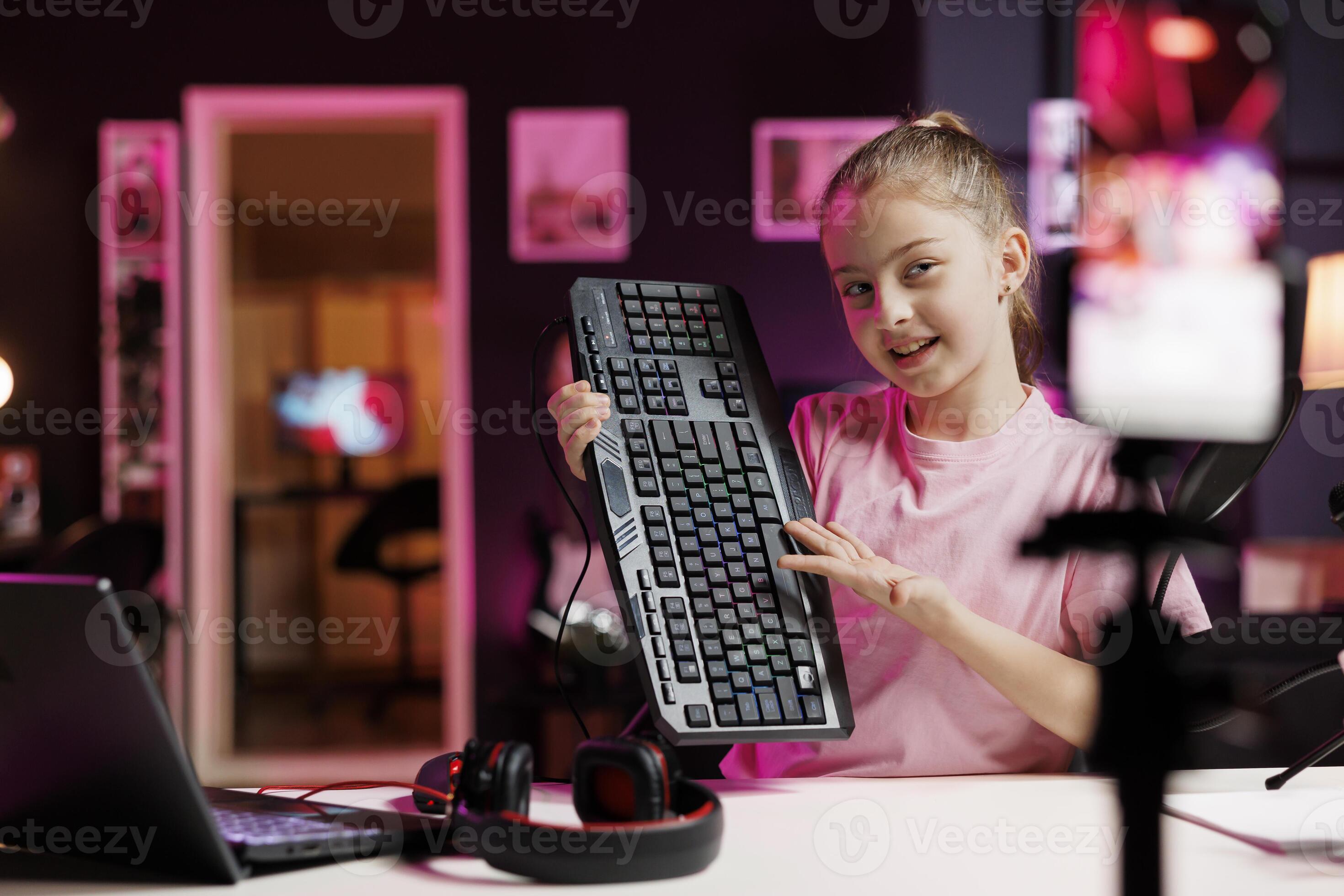 Joyful kid showing viewers mechanical keyboard received from sponsoring brand to promote it. Gen ...