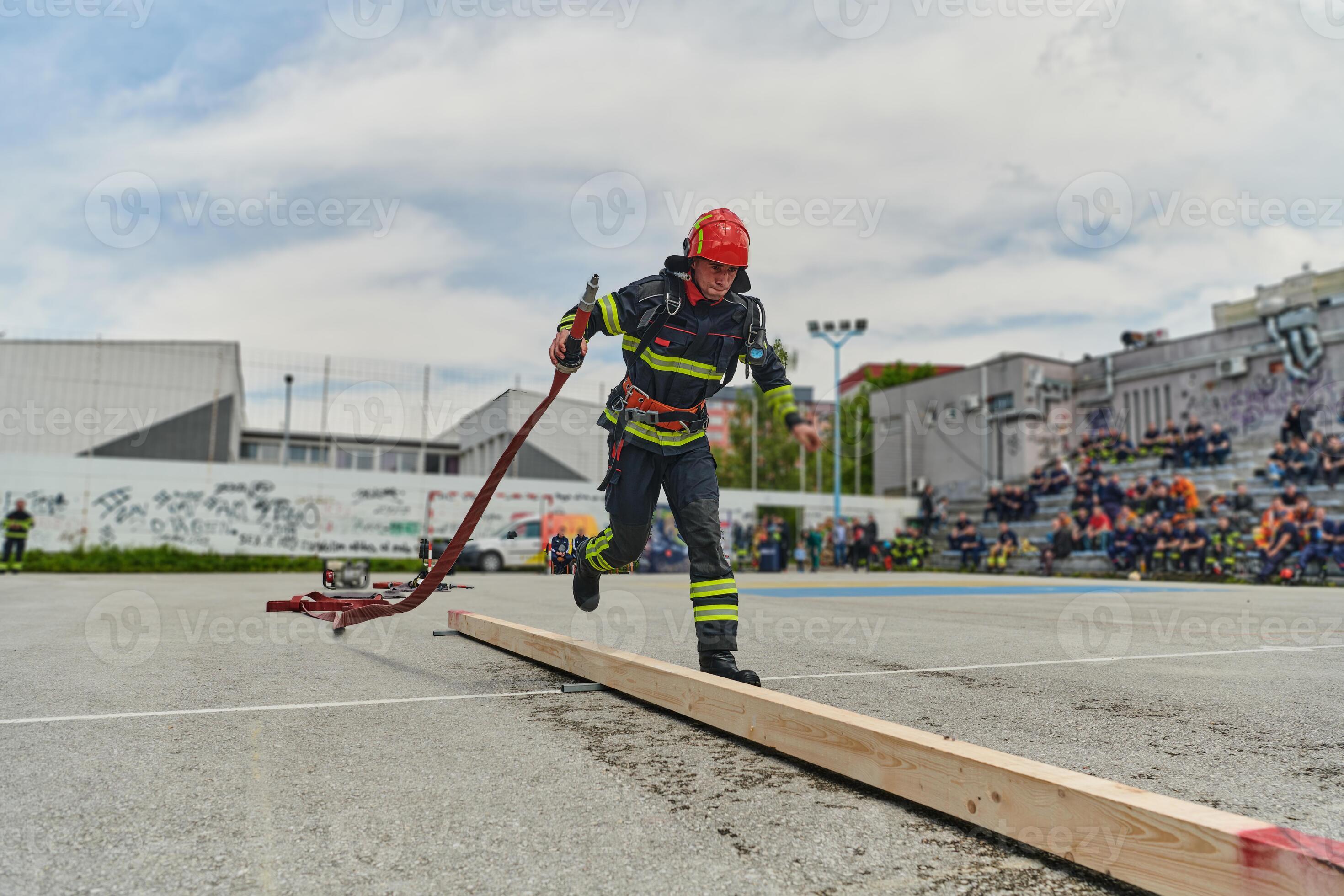 In a dynamic display of synchronized teamwork, firefighters hustle to ... In a dynamic display of synchronized teamwork, firefighters hustle to ...