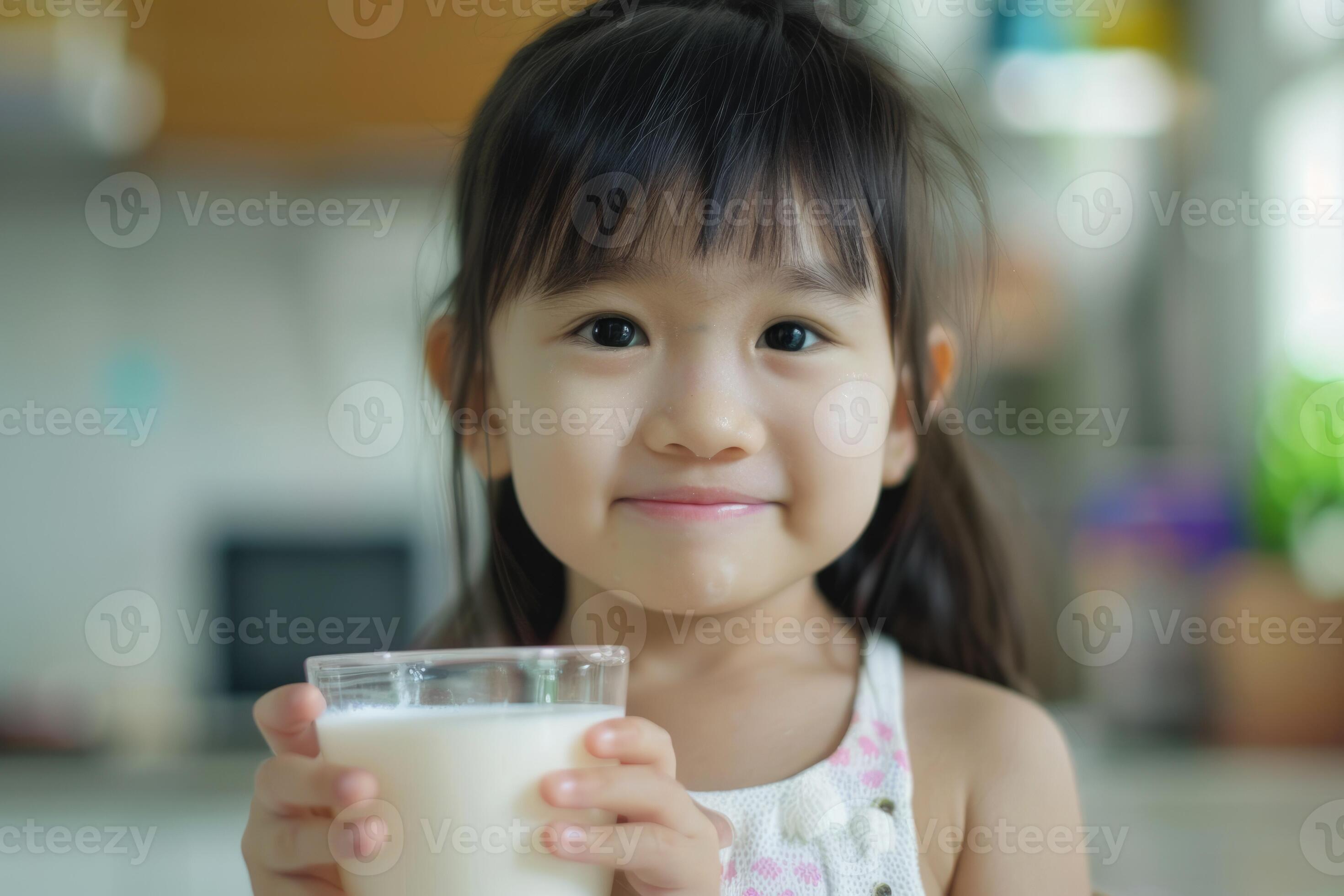 Asian little child girl holding glass of milk in kitchen at home 46174825 Stock Photo at Vecteezy