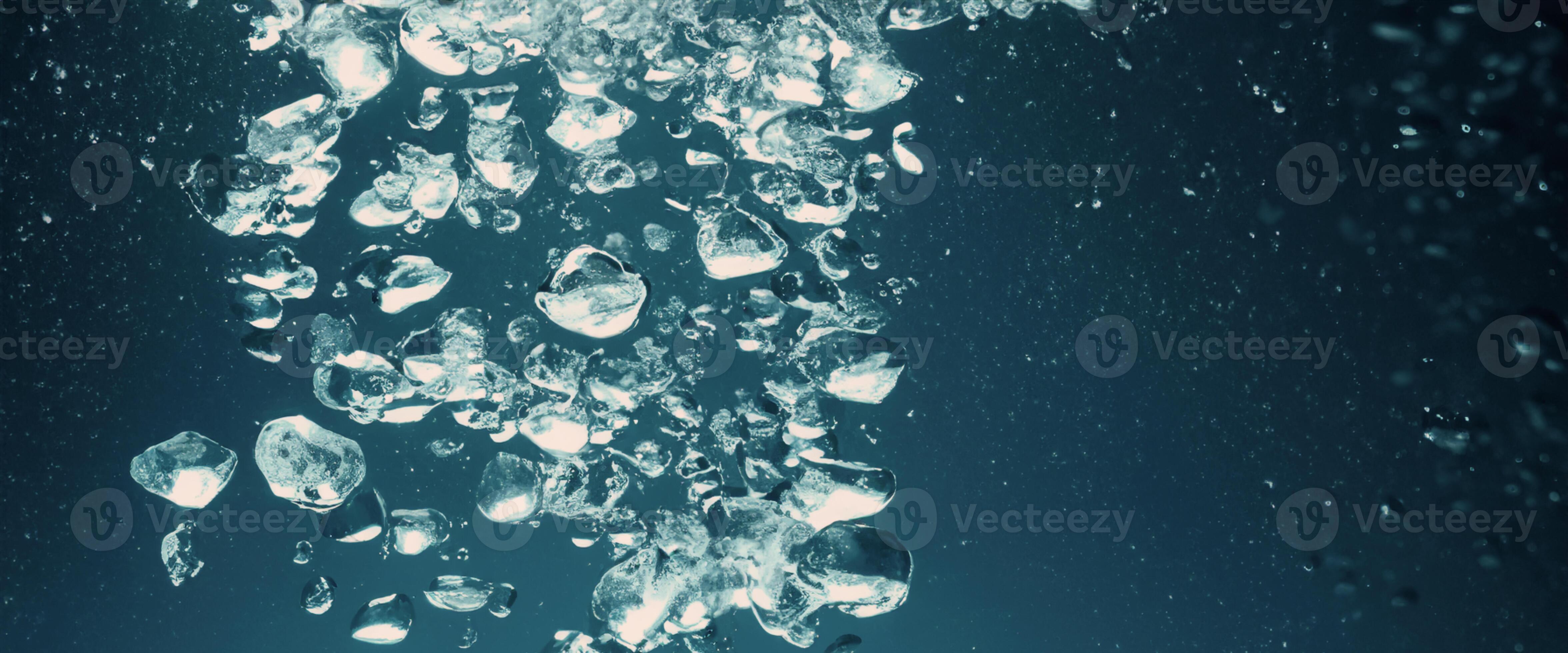 Water splashing and ice cube. Ice splashing into a glass of water. Underwater pouring ice cubes ...