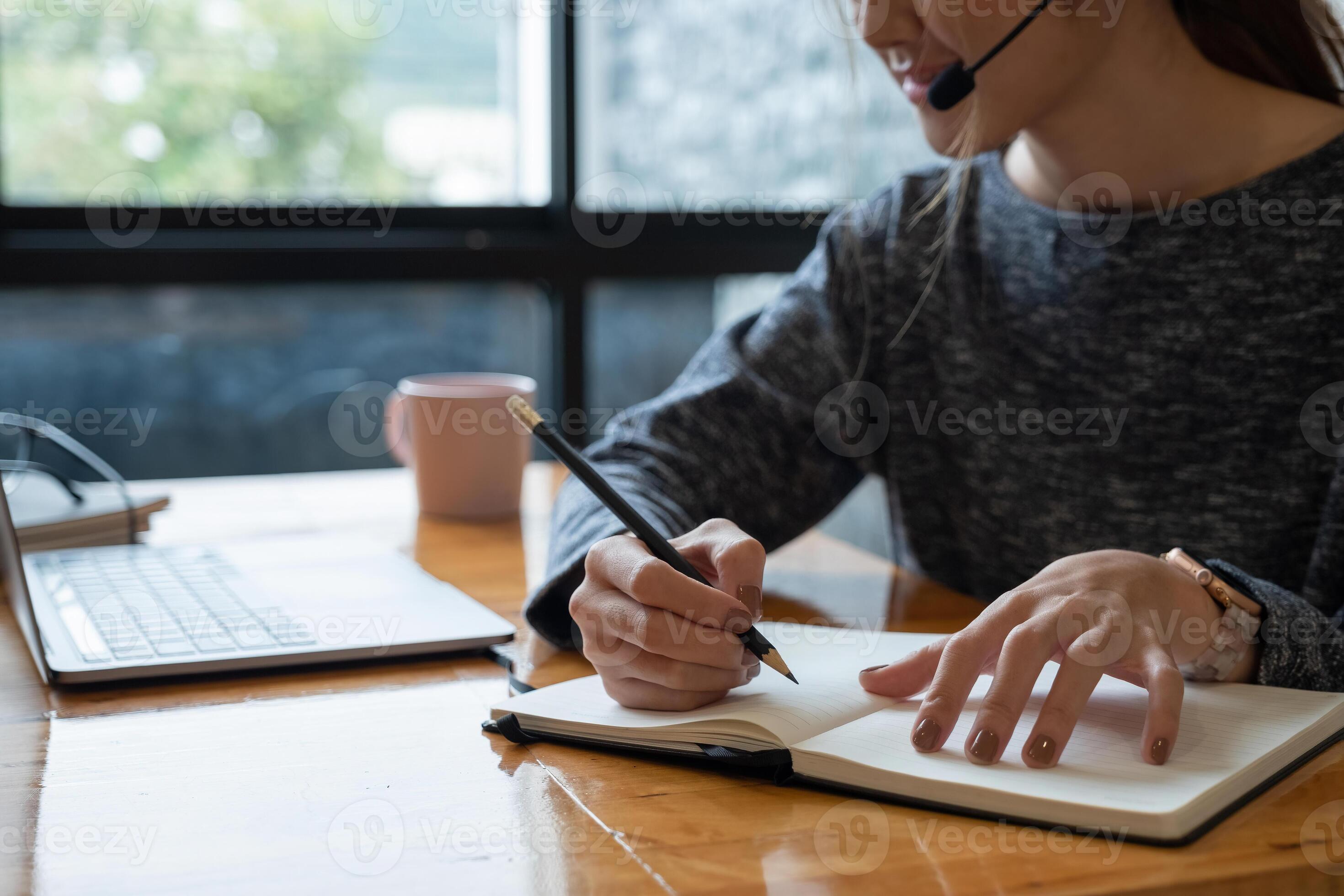 Close up hand of asian woman studying online from home making notes for ...