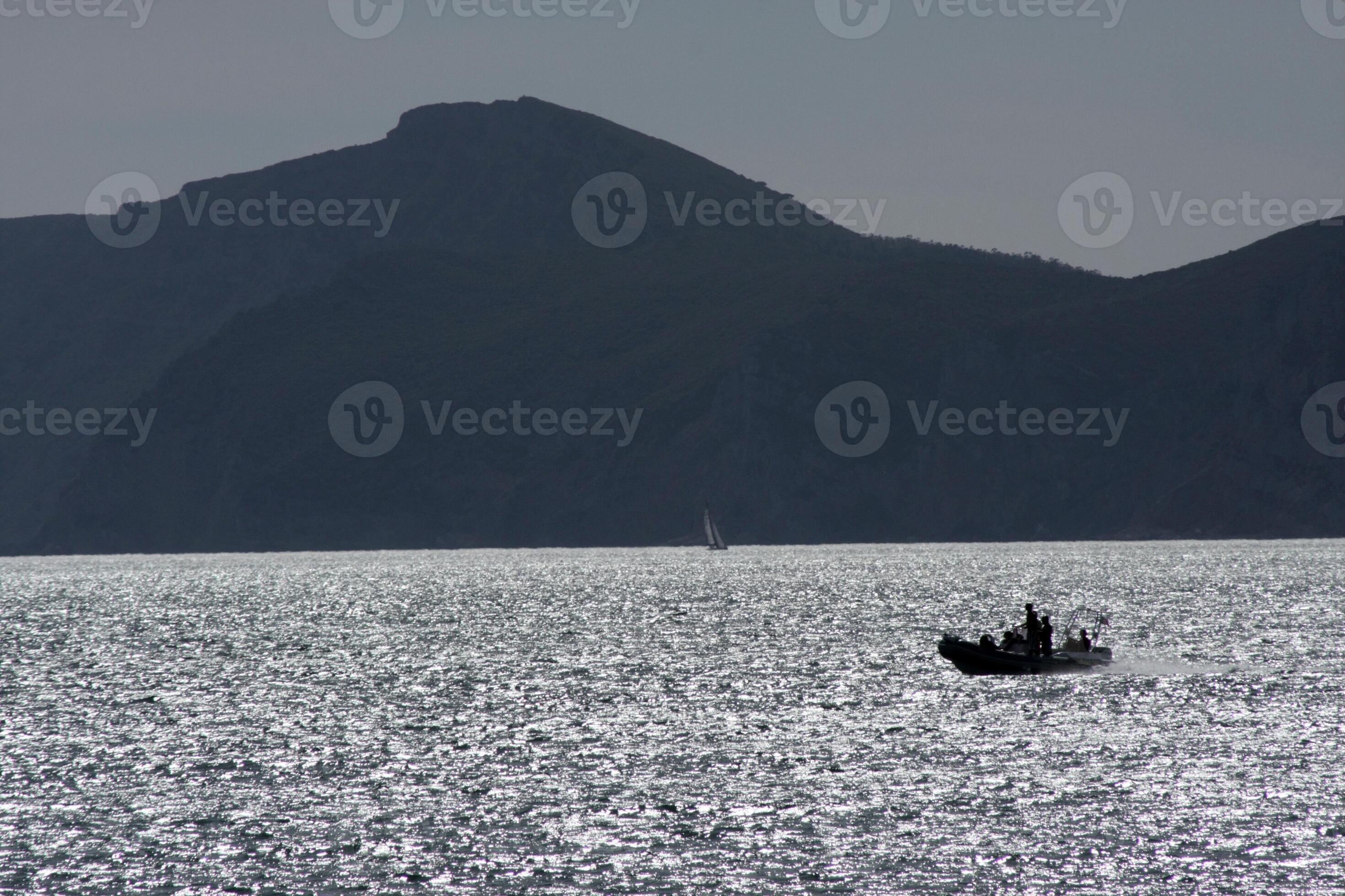 Sailboat gliding past the stunning Serra da Arrabida backdrop in Setubal, Portugal. Serene ...