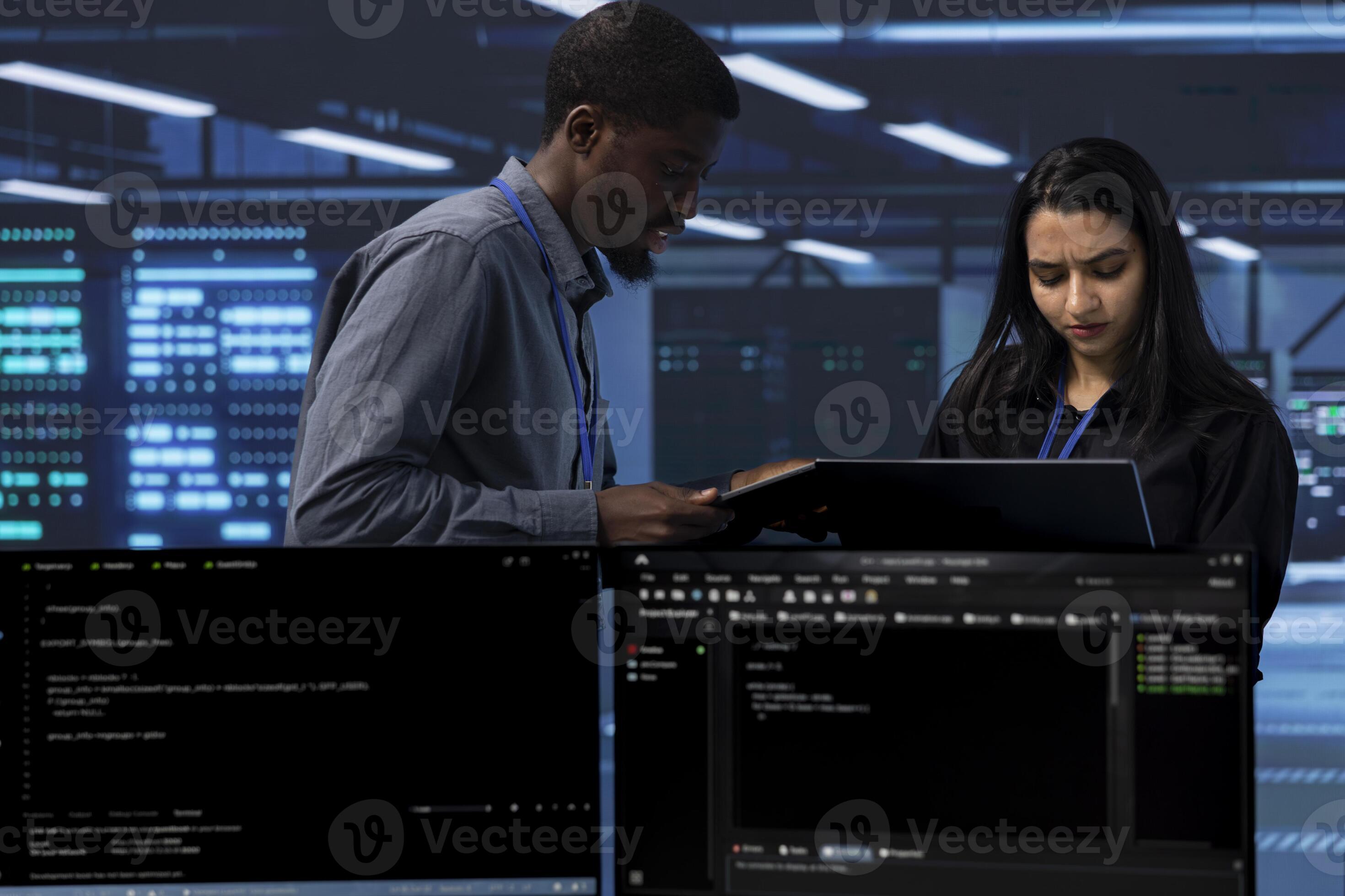 Engineers in server farm checking recovery plan, monitoring tech equipment energy consumption ...