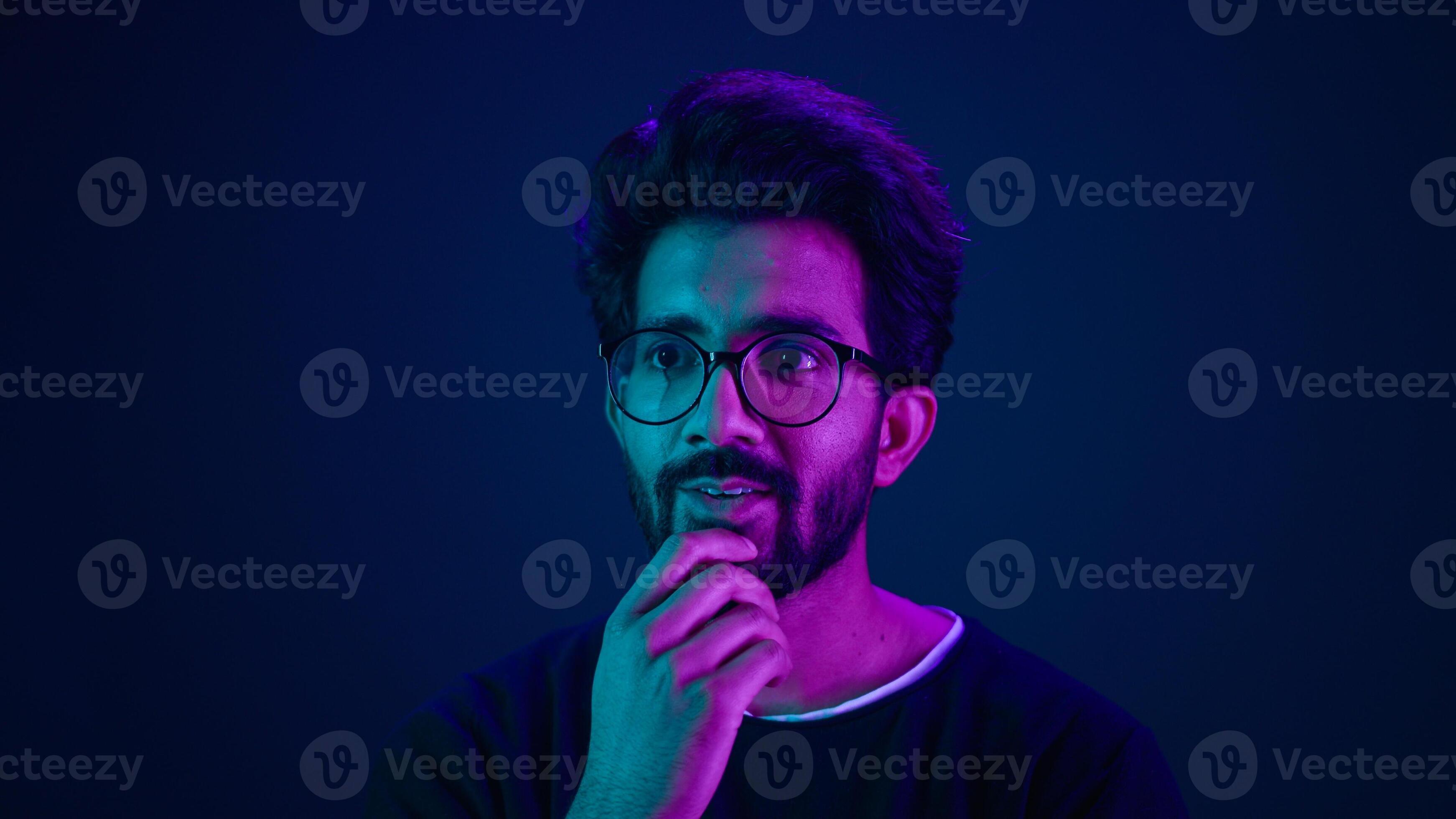 Close up male portrait in neon studio ultraviolet background blue backdrop Arabian Muslim ...